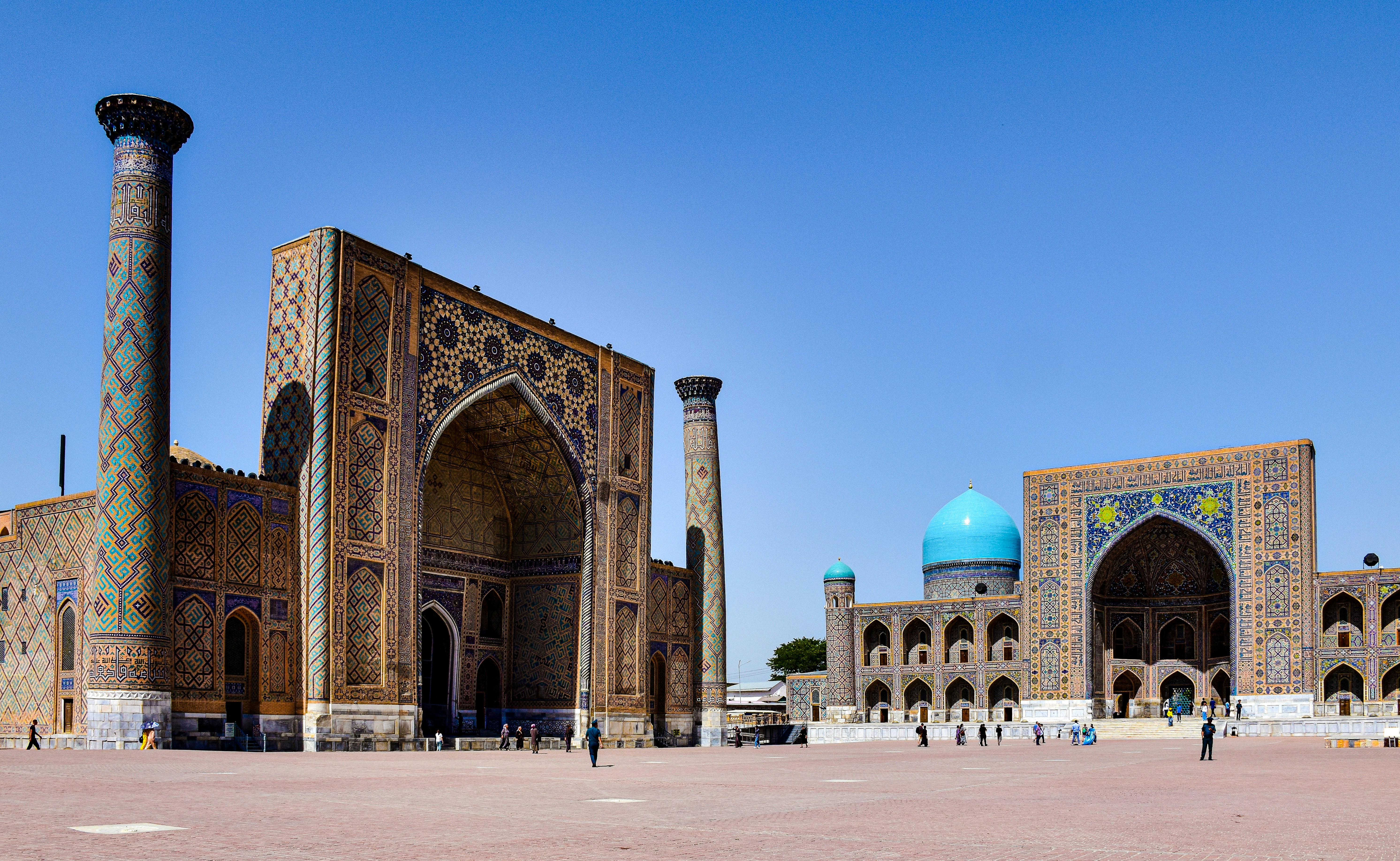 A large building with pillars with Registan in the background photo ...