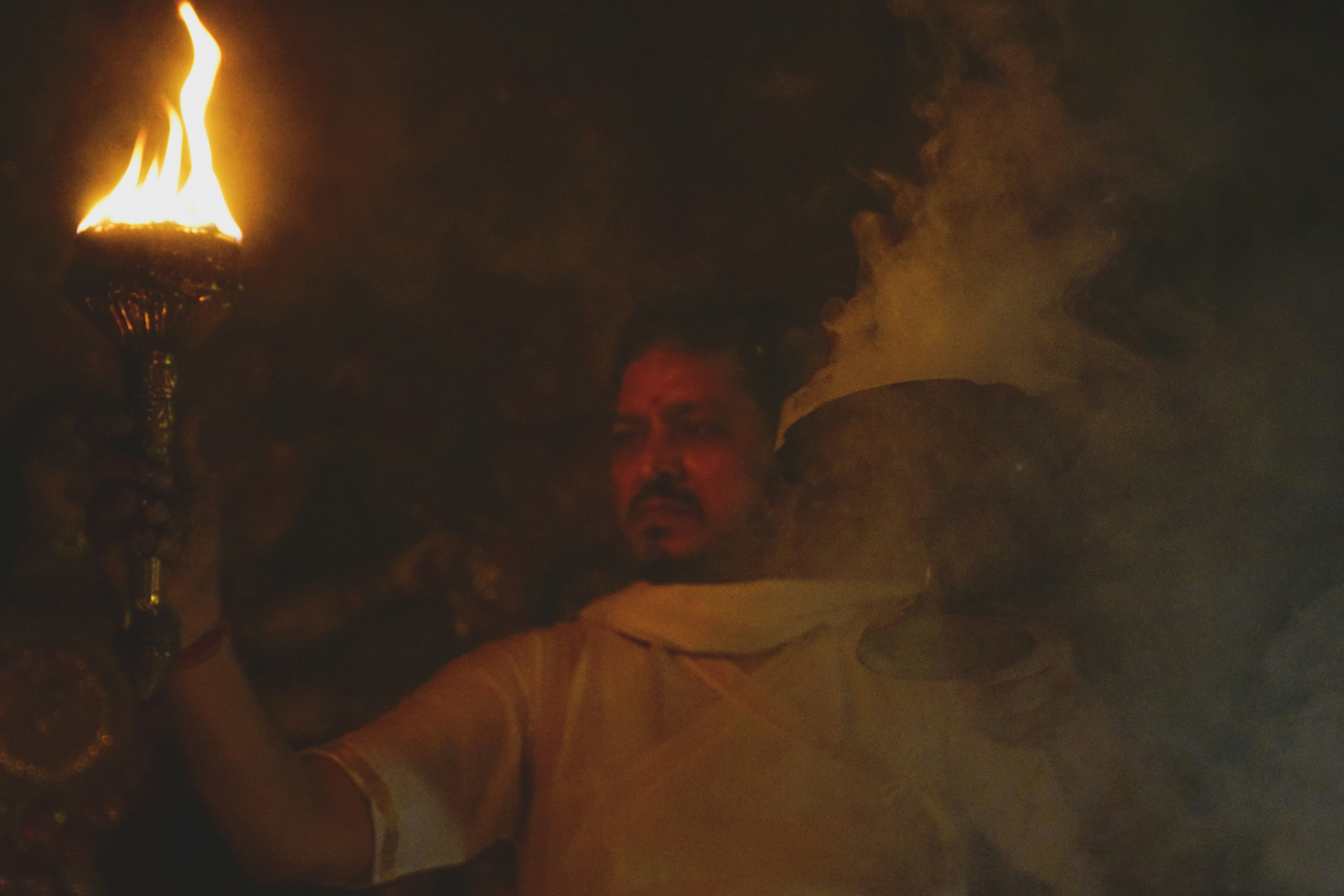 A man sitting in a chair with a fire in the back photo – Free Light ...