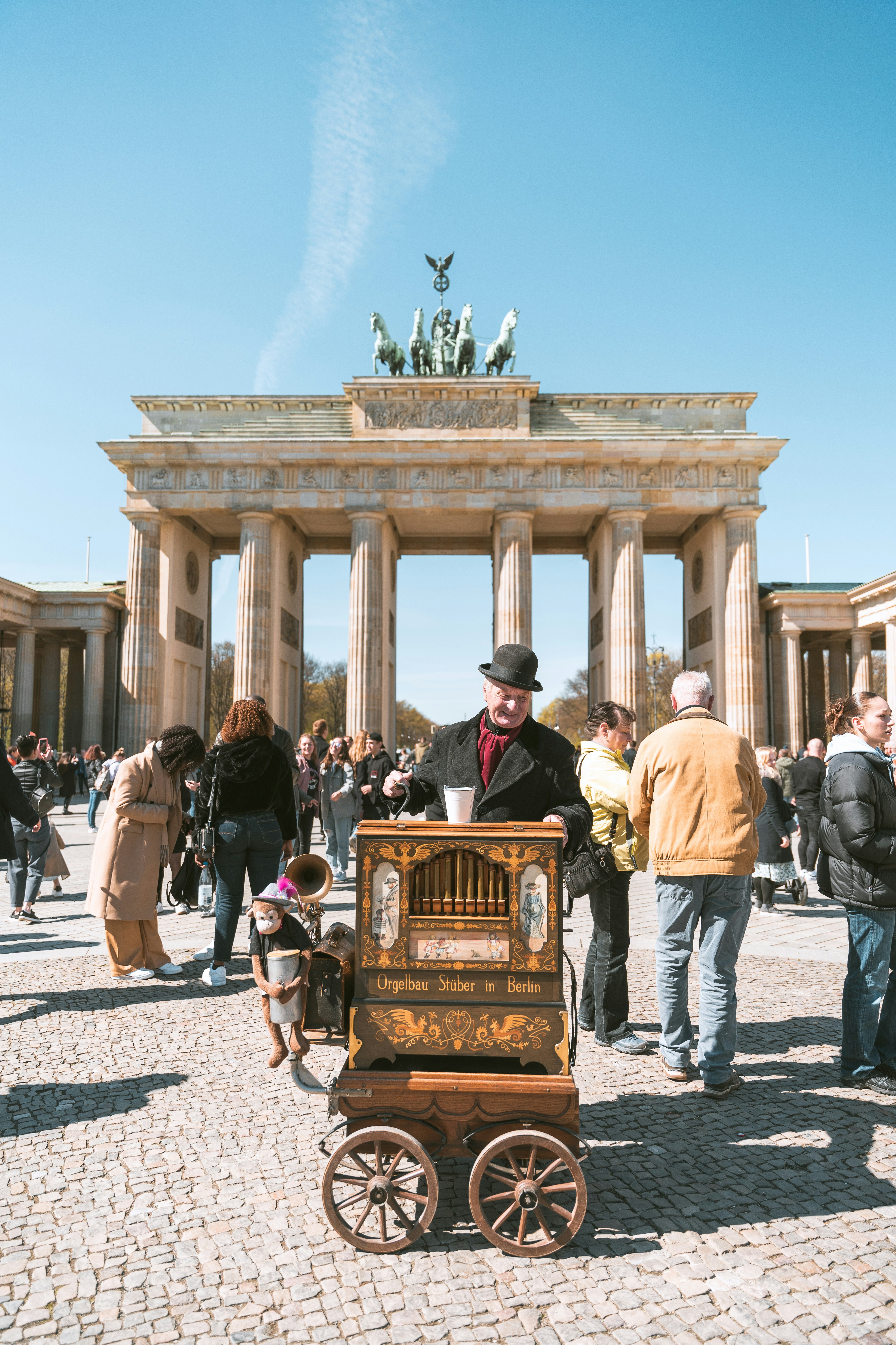 a person in a hat standing next to a cart with a statue on top of it