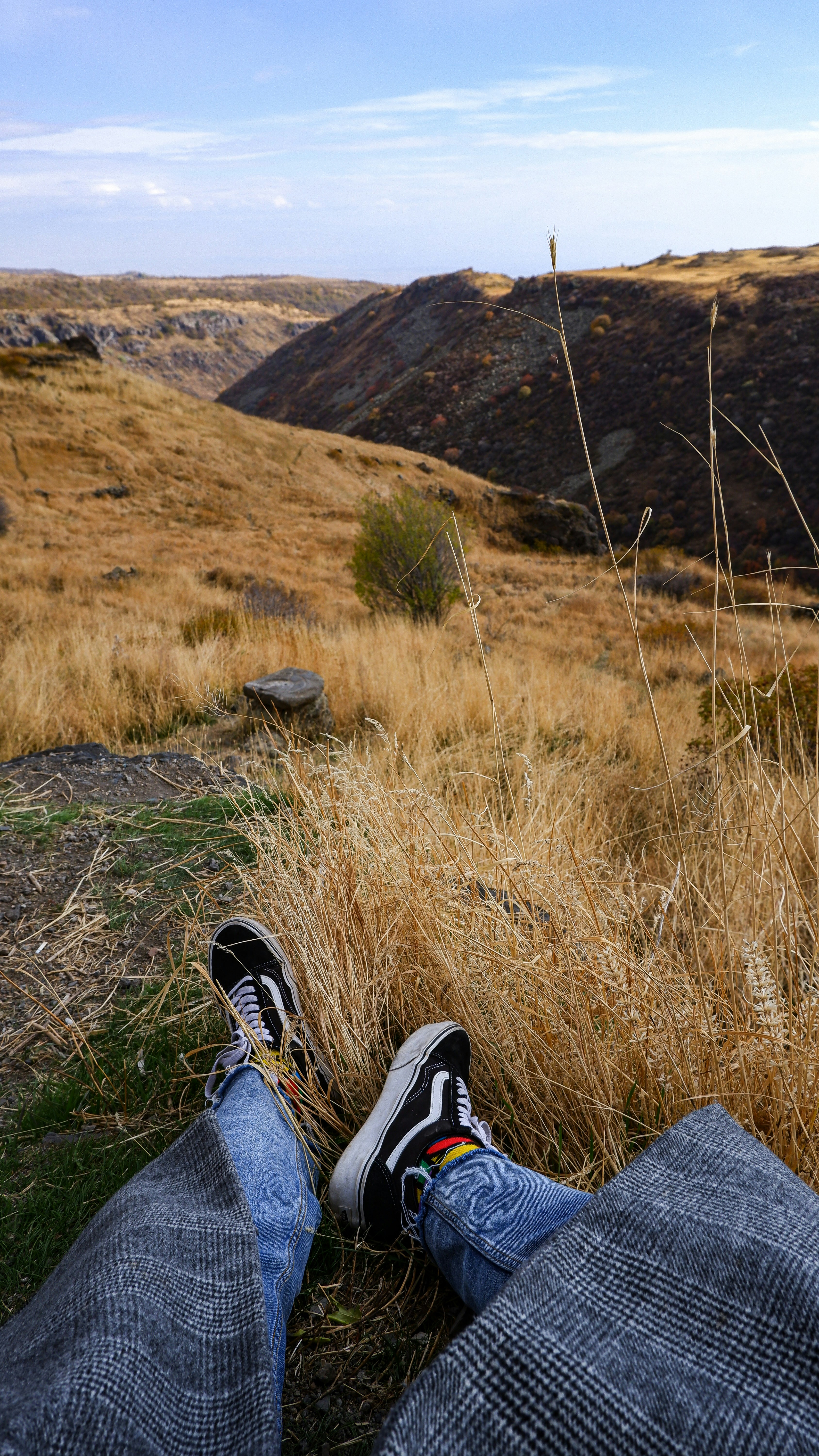 A person's legs and feet on a rock ledge overlooking a valley photo ...