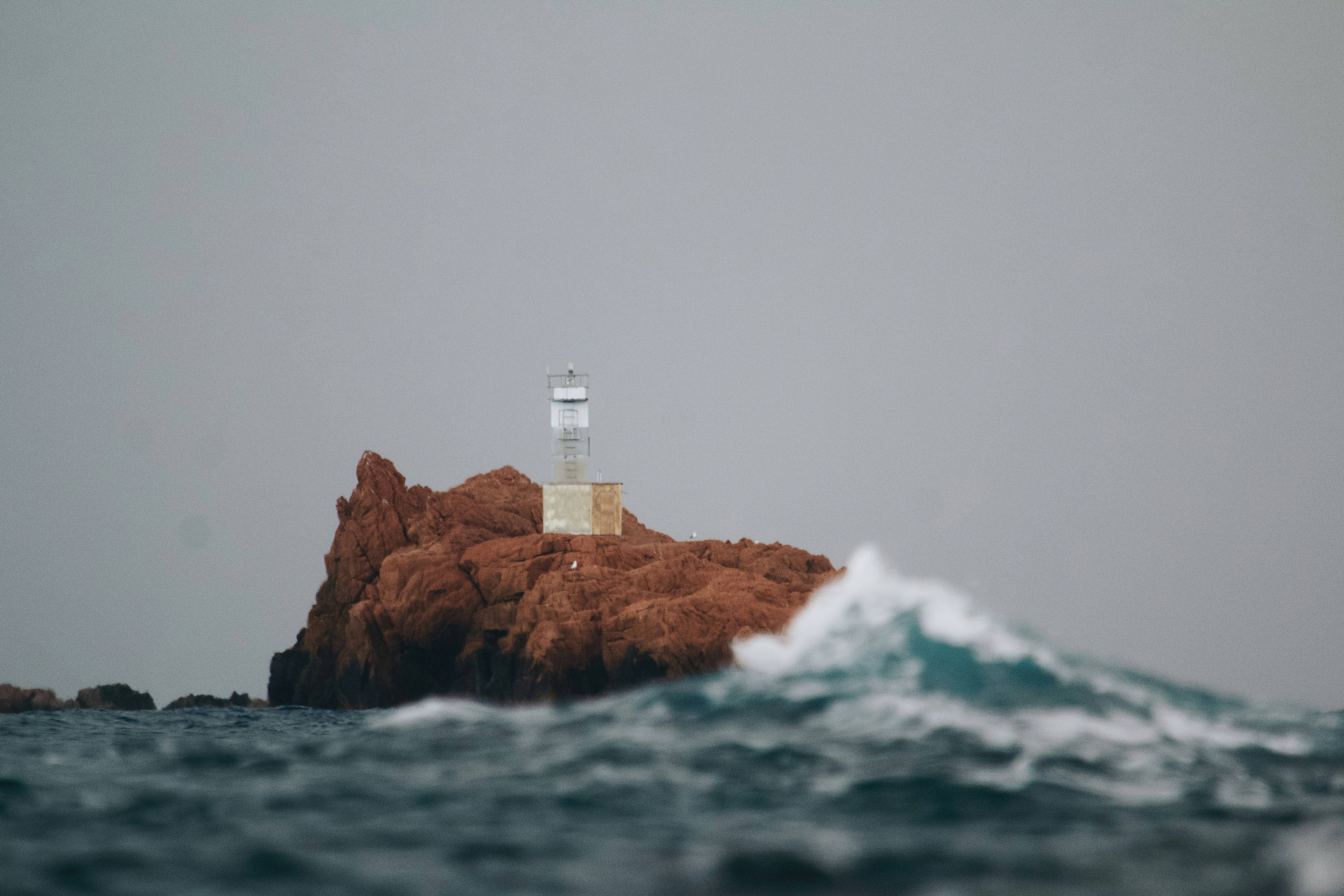 A lighthouse on a rock in the ocean photo – Free Palamós Image on Unsplash