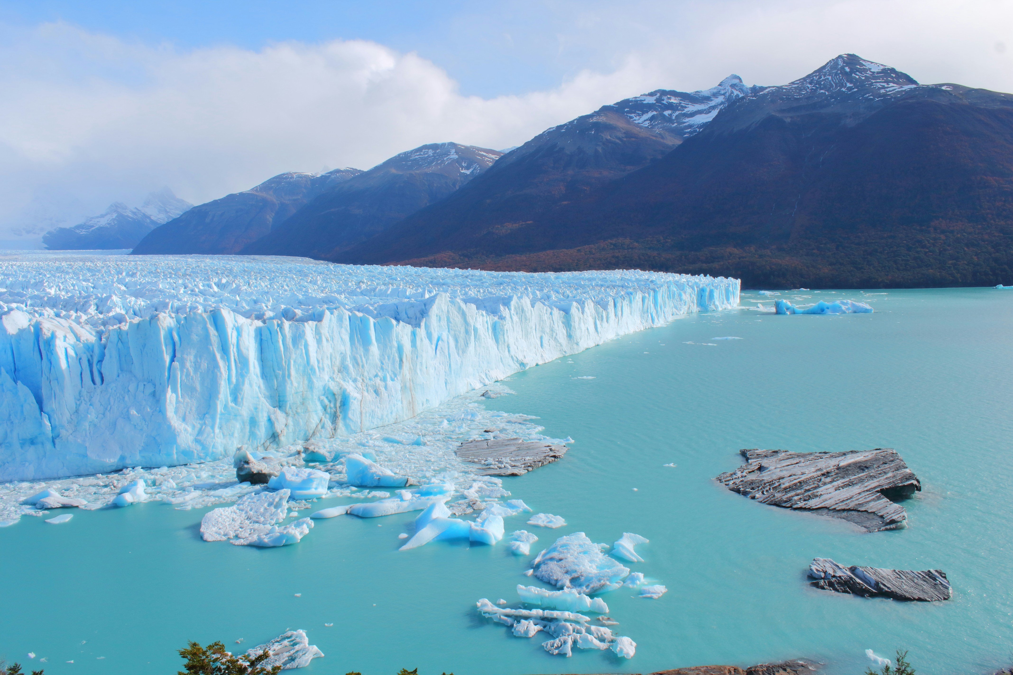 Foto Uma grande geleira na água com o Glaciar Perito Moreno ao fundo ...