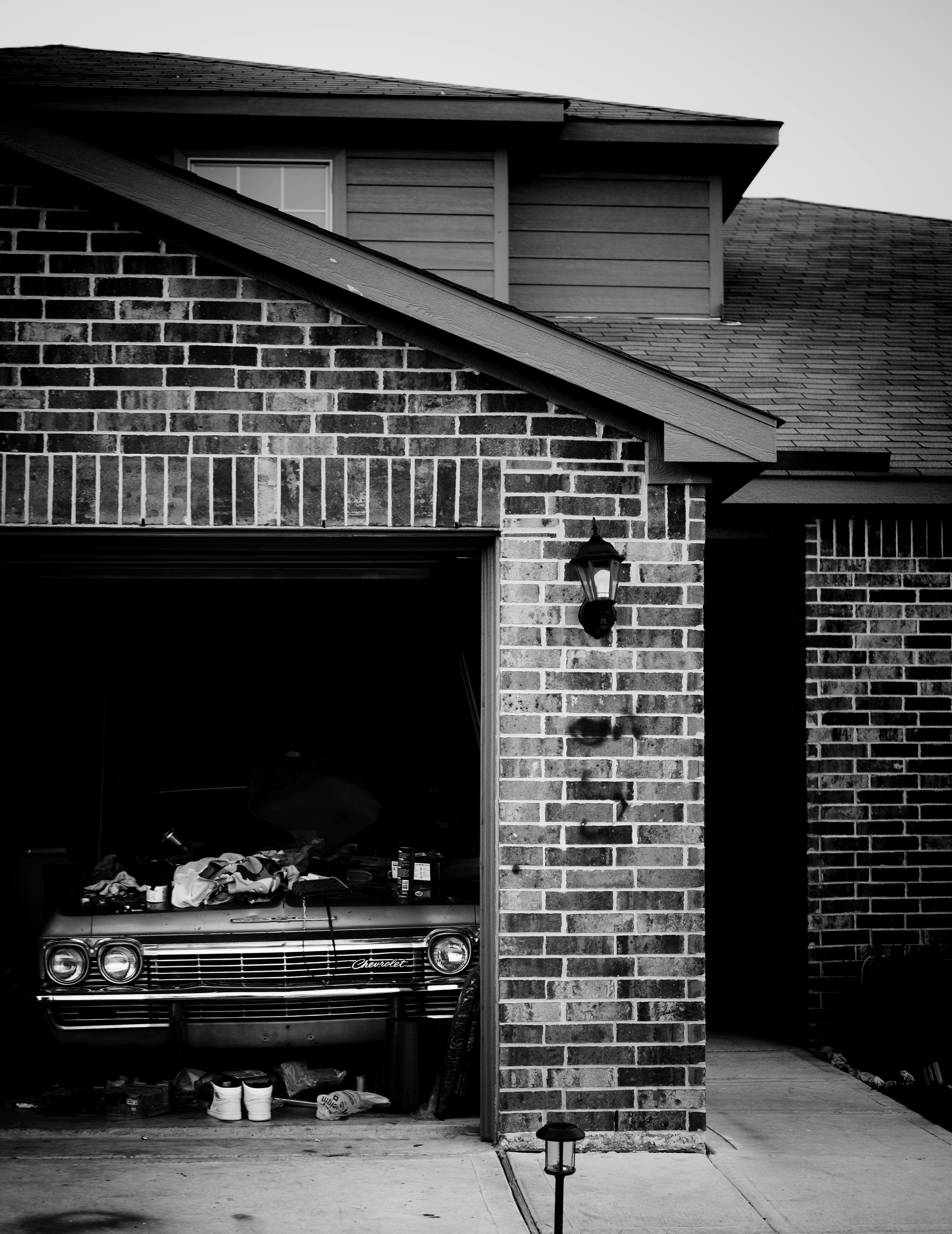 Brick Vault, Chrome Heart: A Vintage Car Rests in a Dim Garage