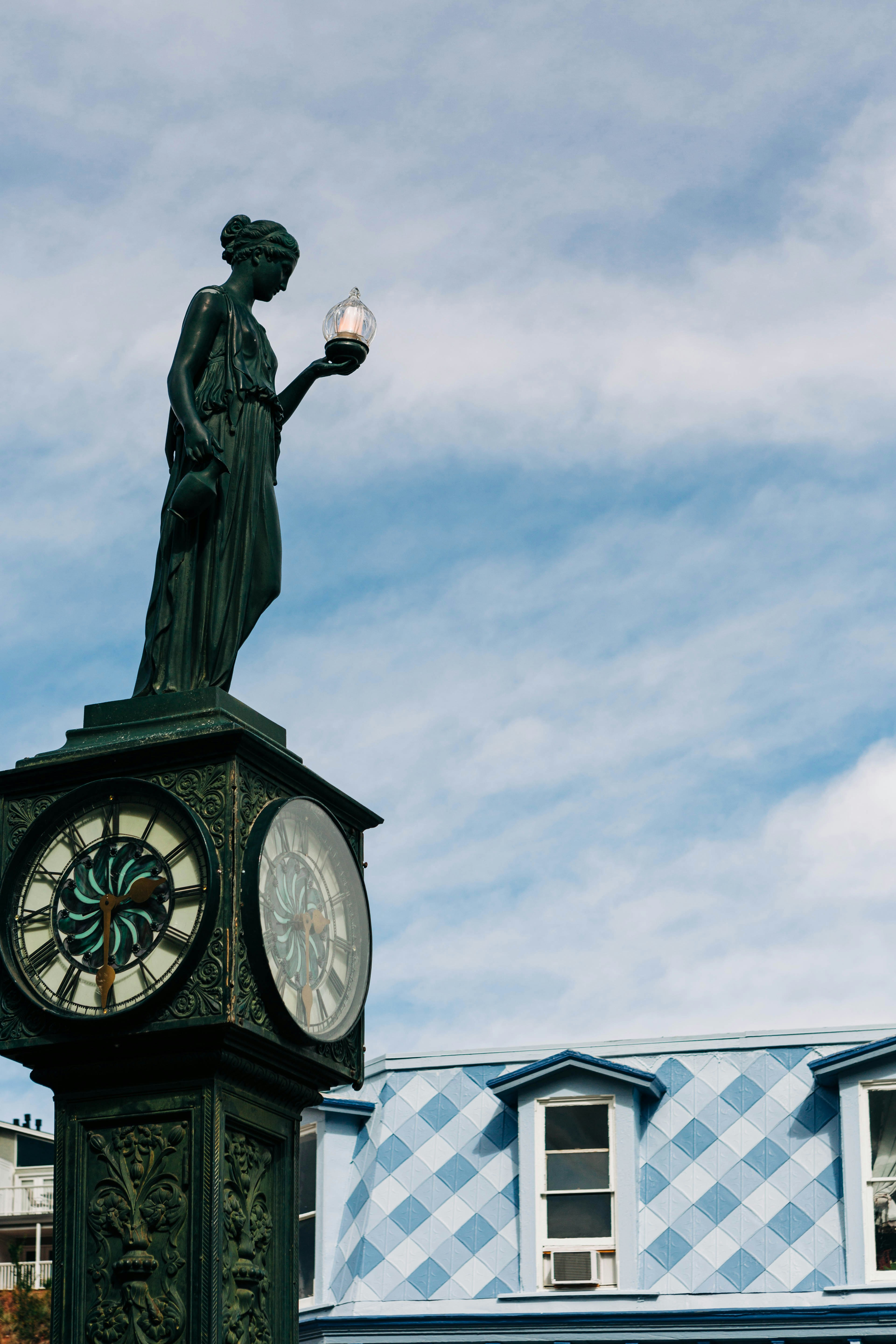 Timekeeping Muse: A bronze guardian above a patterned roofline