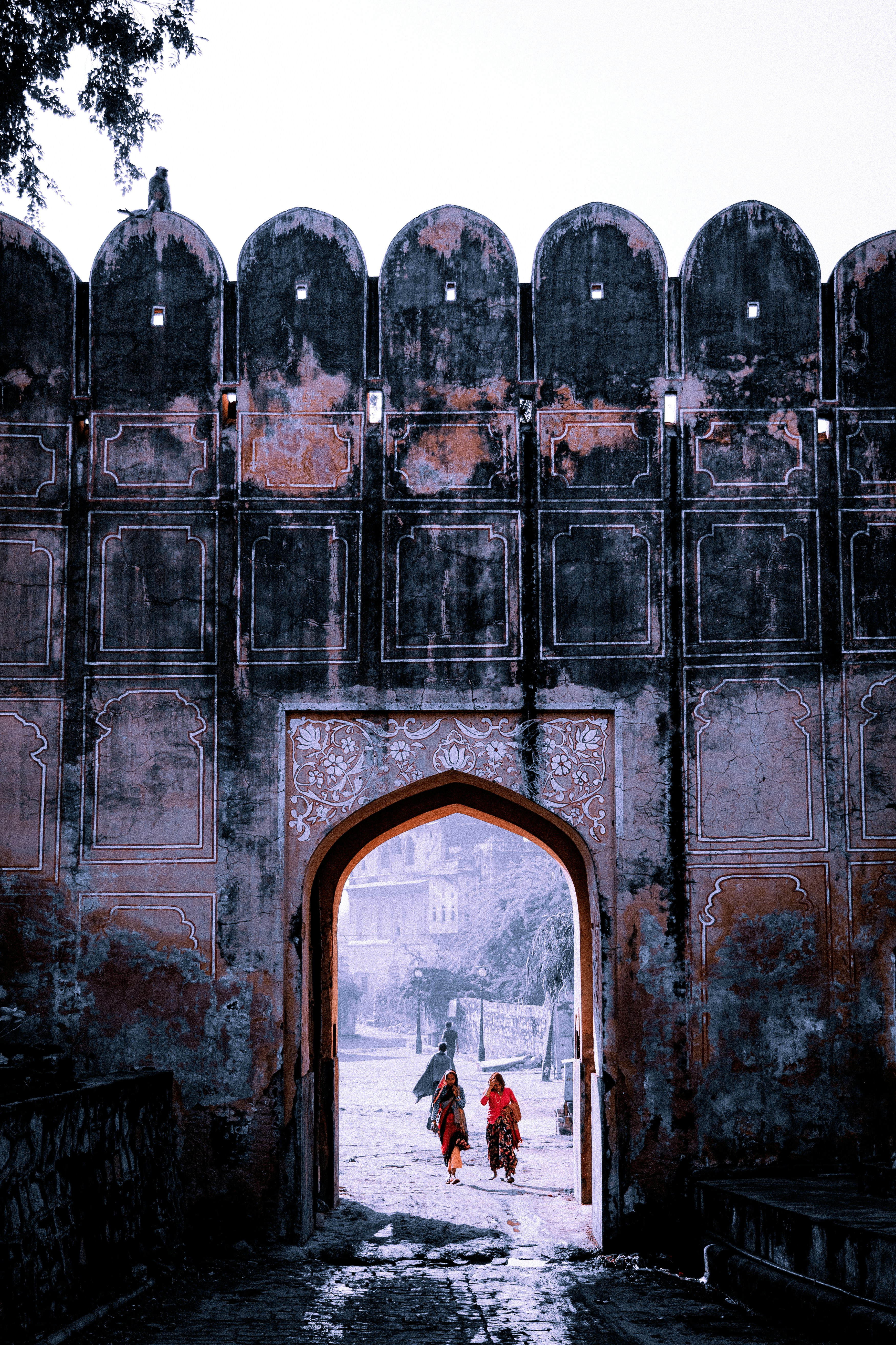 A couple of people walking through a gate photo – Free City Image on ...