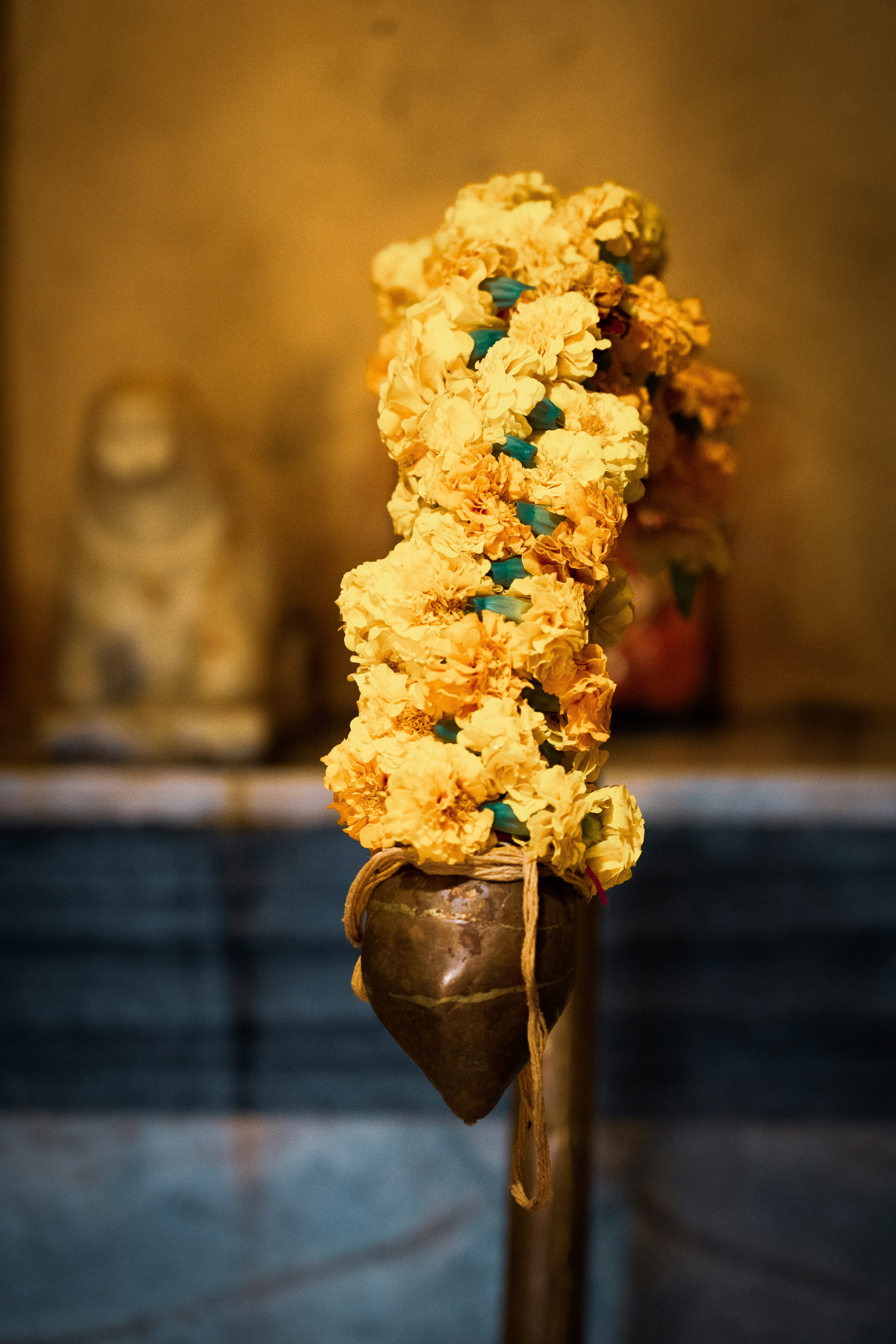 Marigold Halo: A Bronze Bell Framed by a Sacred Garland