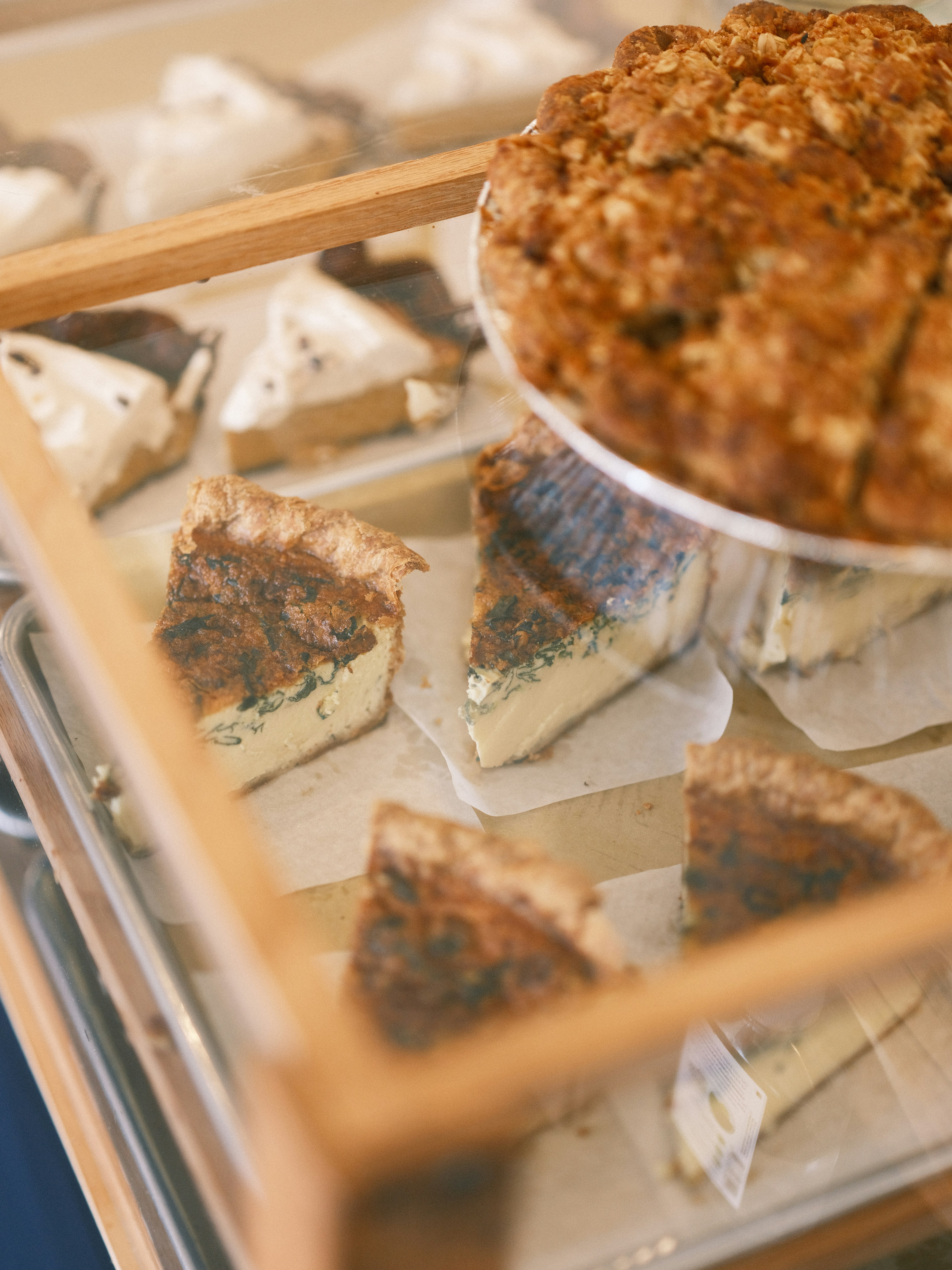 Crumb-Topped Cheesecake Framed by a Warm Bakery Display