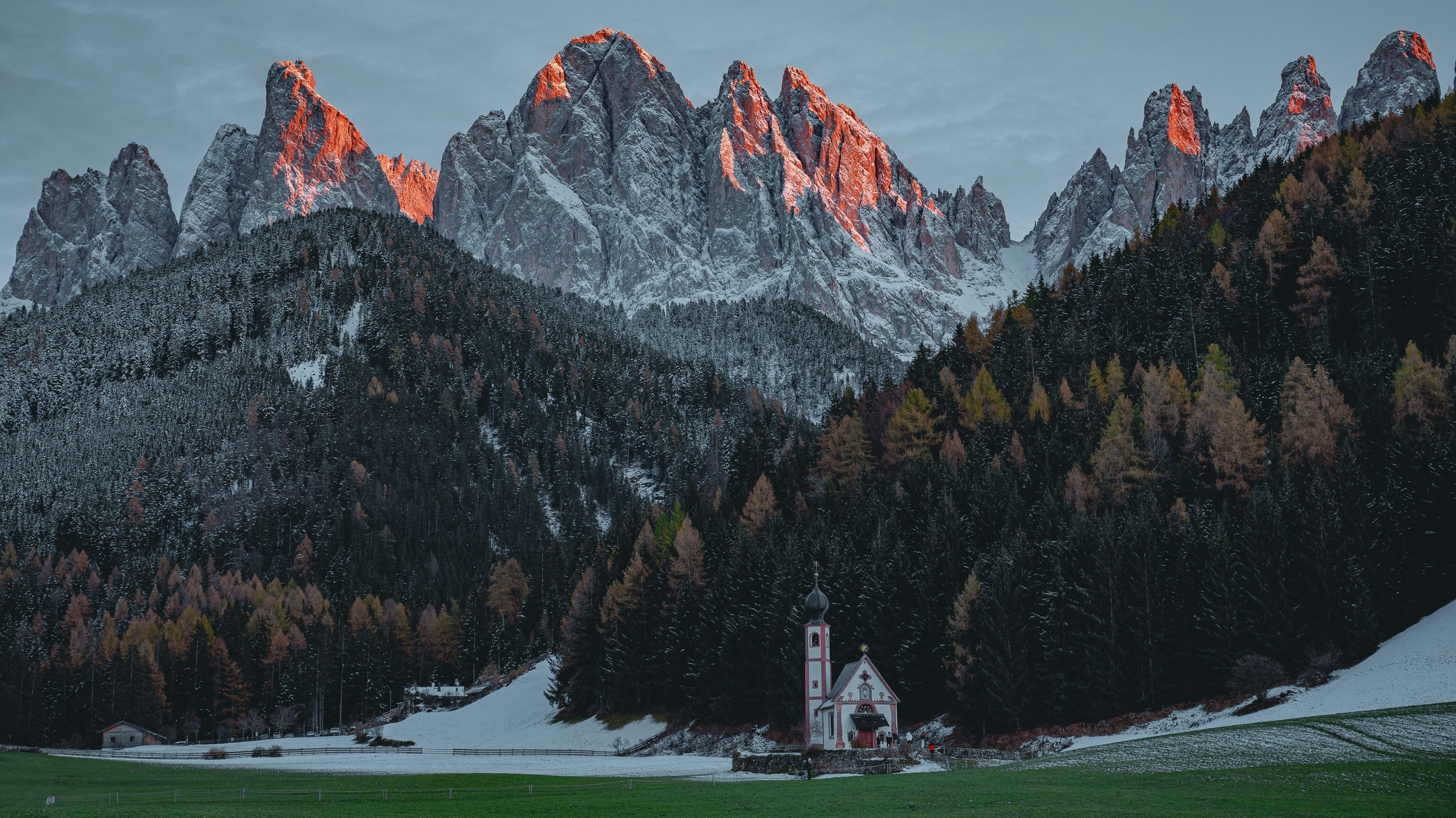 Crimson-tipped Peaks Over a Snow-Blanketed Valley with a Silent Chapel