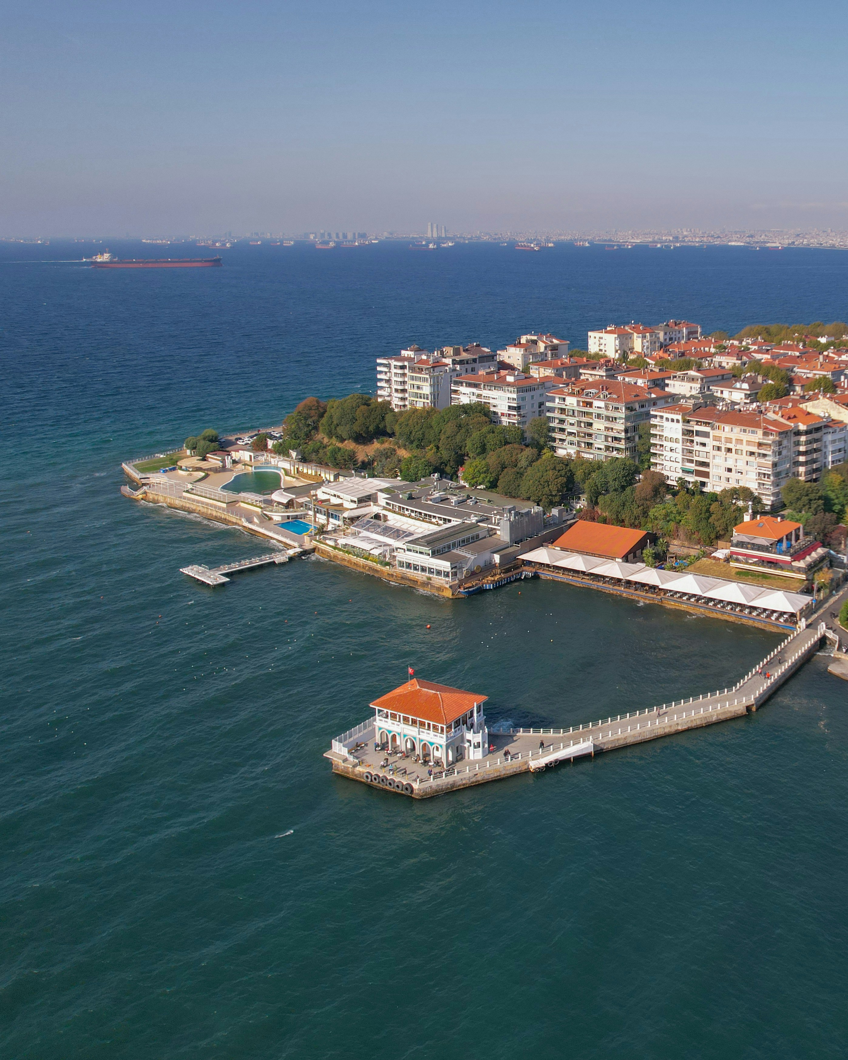 Red-Roof Pavilion at the Pier's Tip Over a Turquoise Coastal Bay