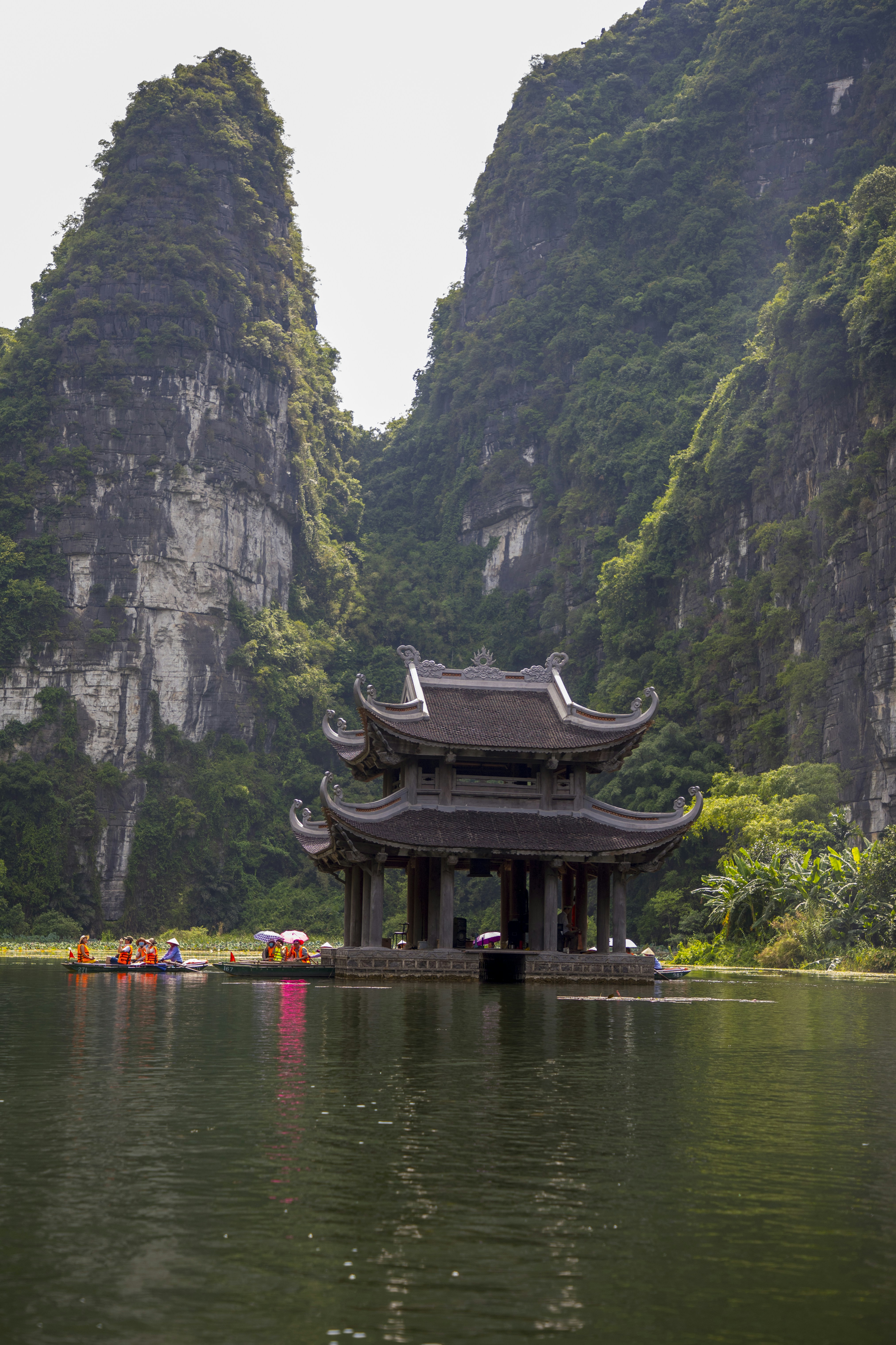 Stone Pavilion Between Limestone Giants on a Quiet Lake