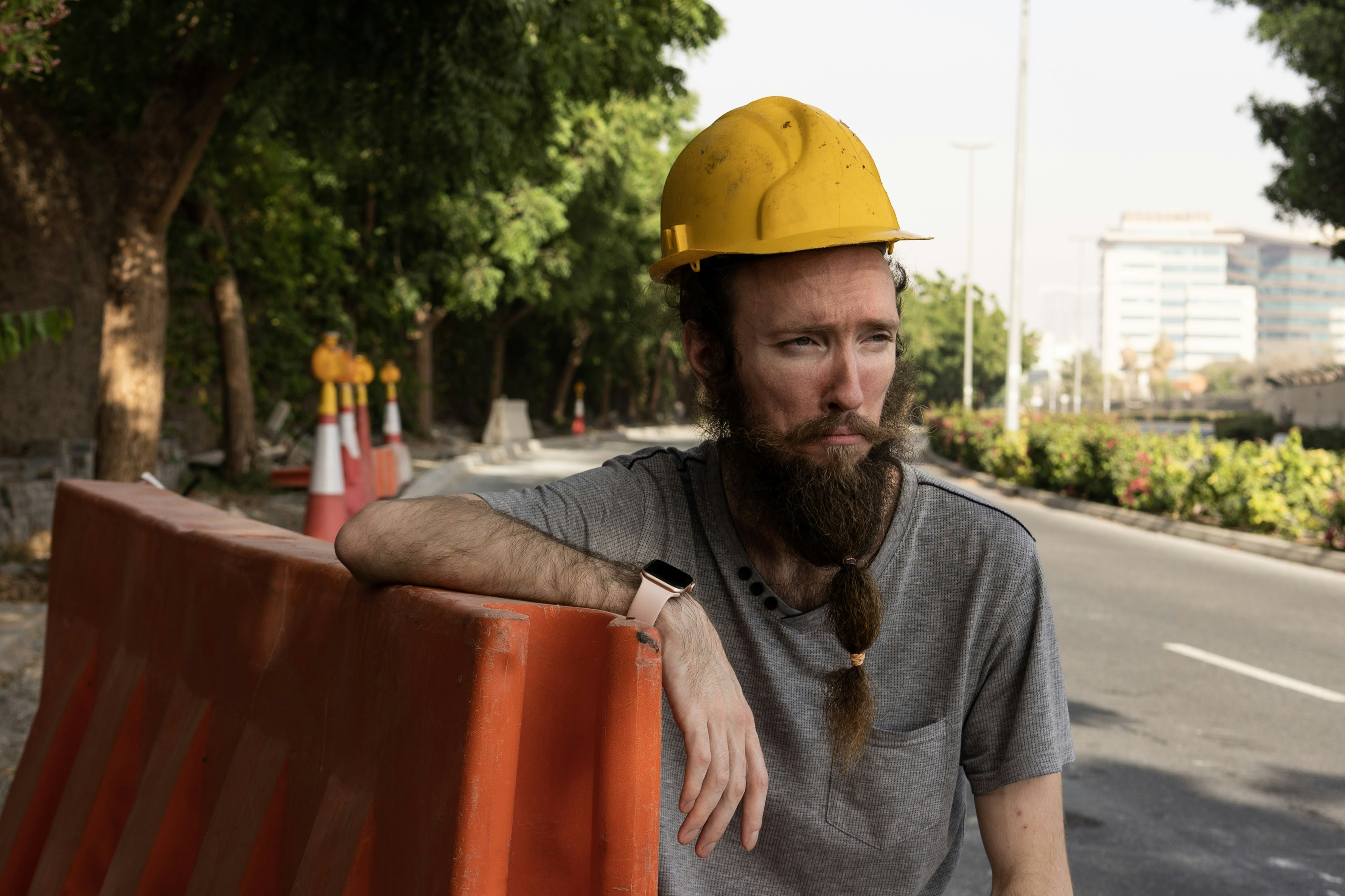 Gaze at the Urban Edge: Bearded Worker in a Yellow Helmet