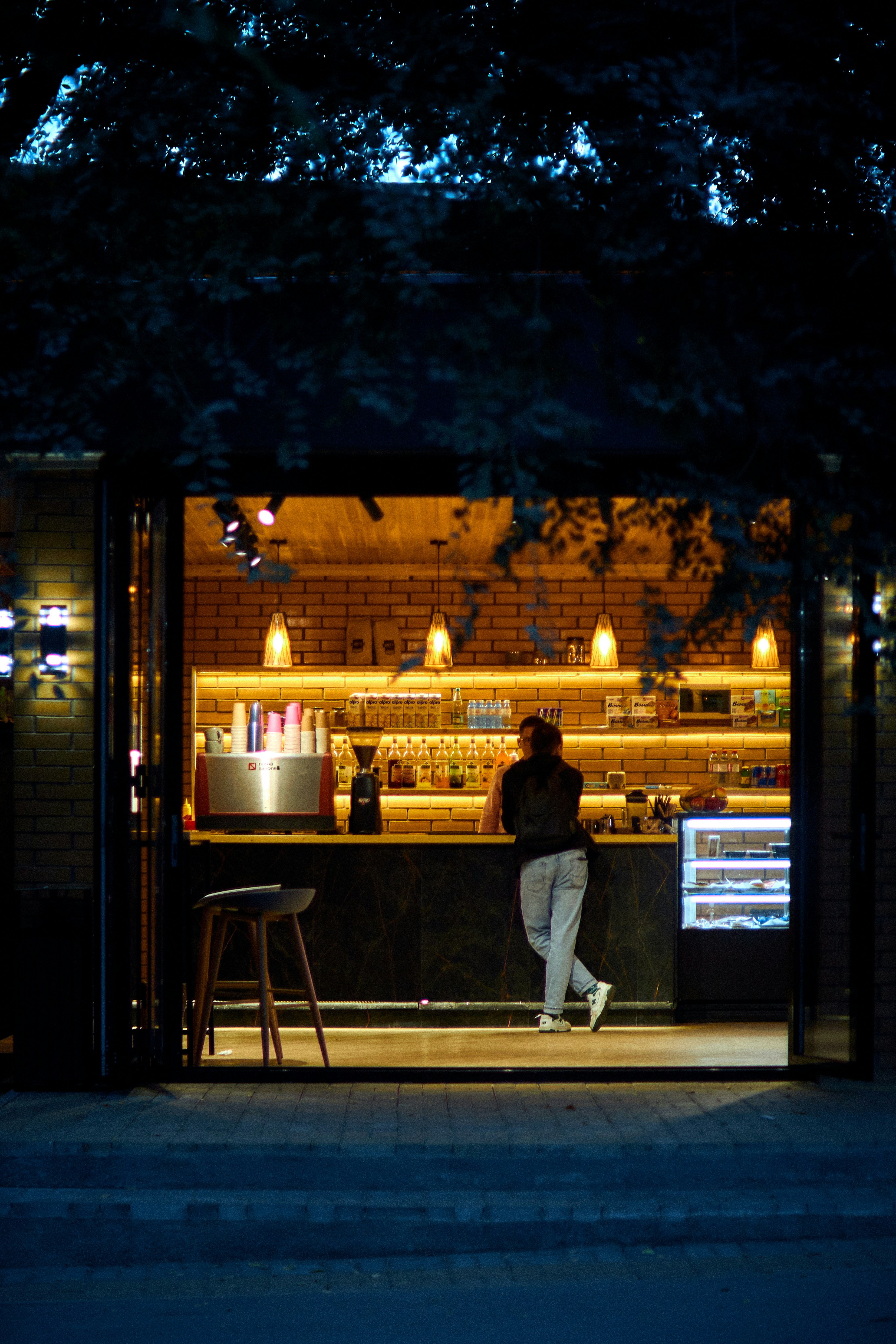 Foto Una persona parada frente a un bar – Imagen gratis en Unsplash