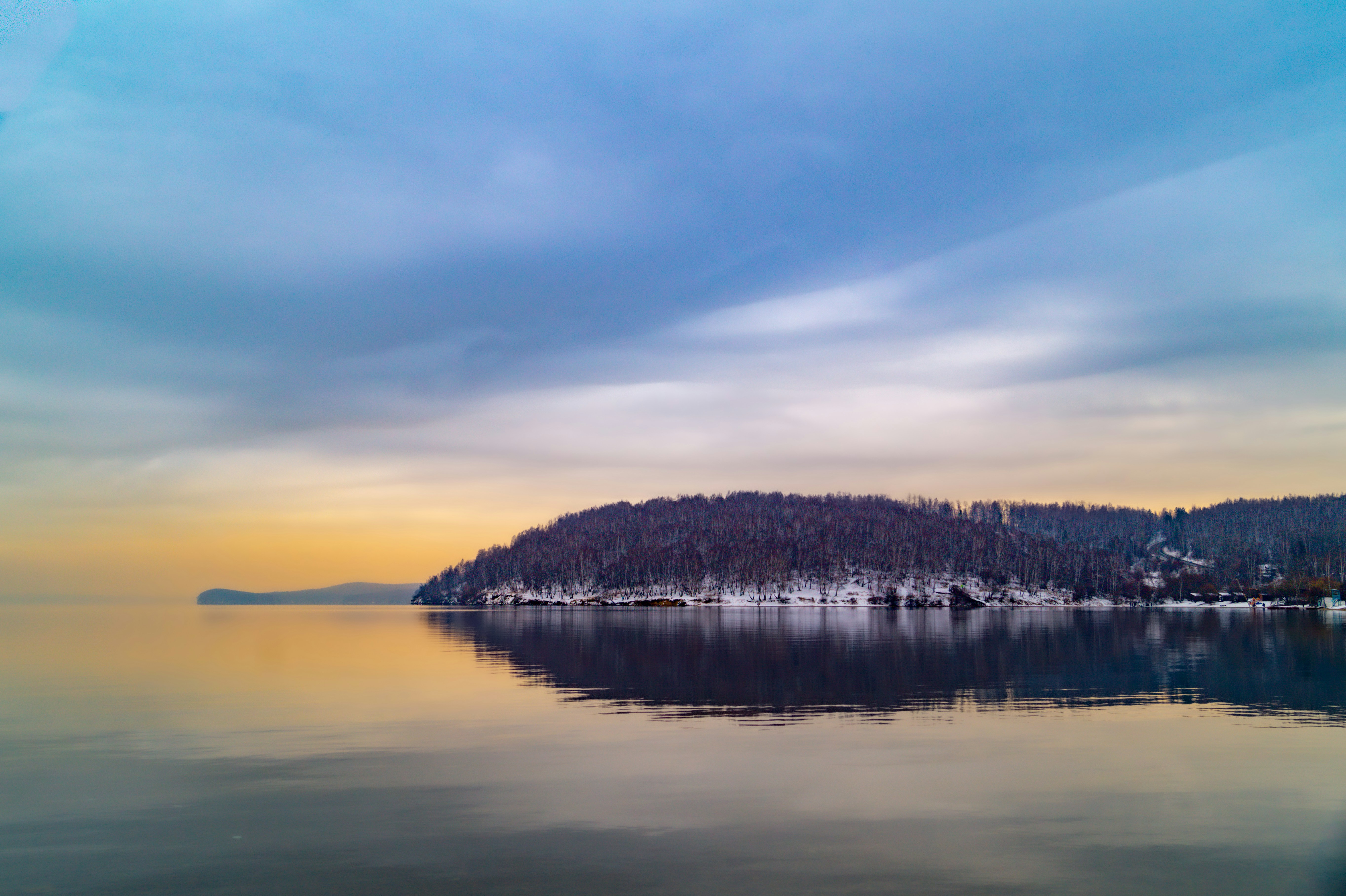 a body of water with a hill in the background