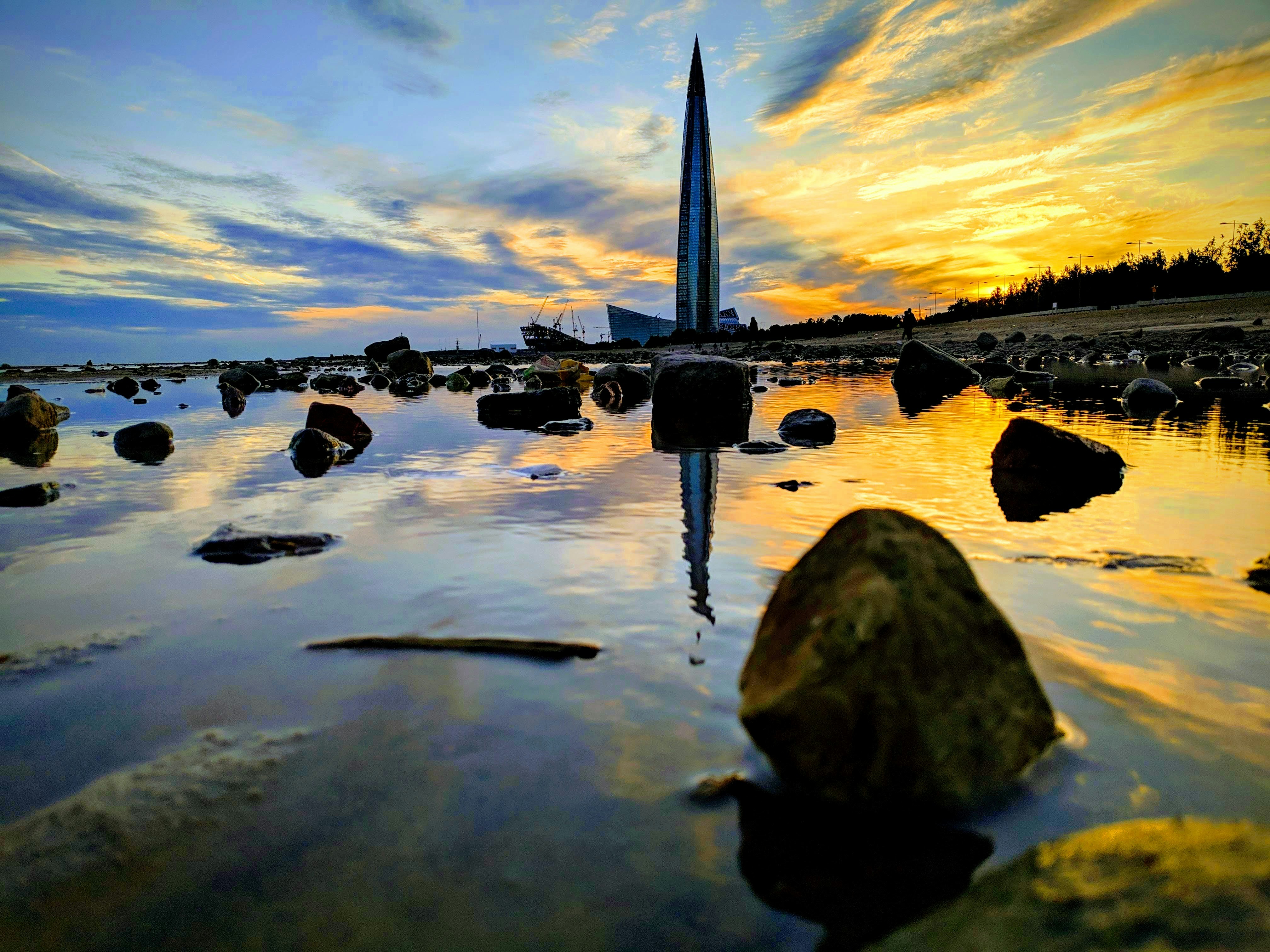 Dusk Spire Over a Pebbled Tide