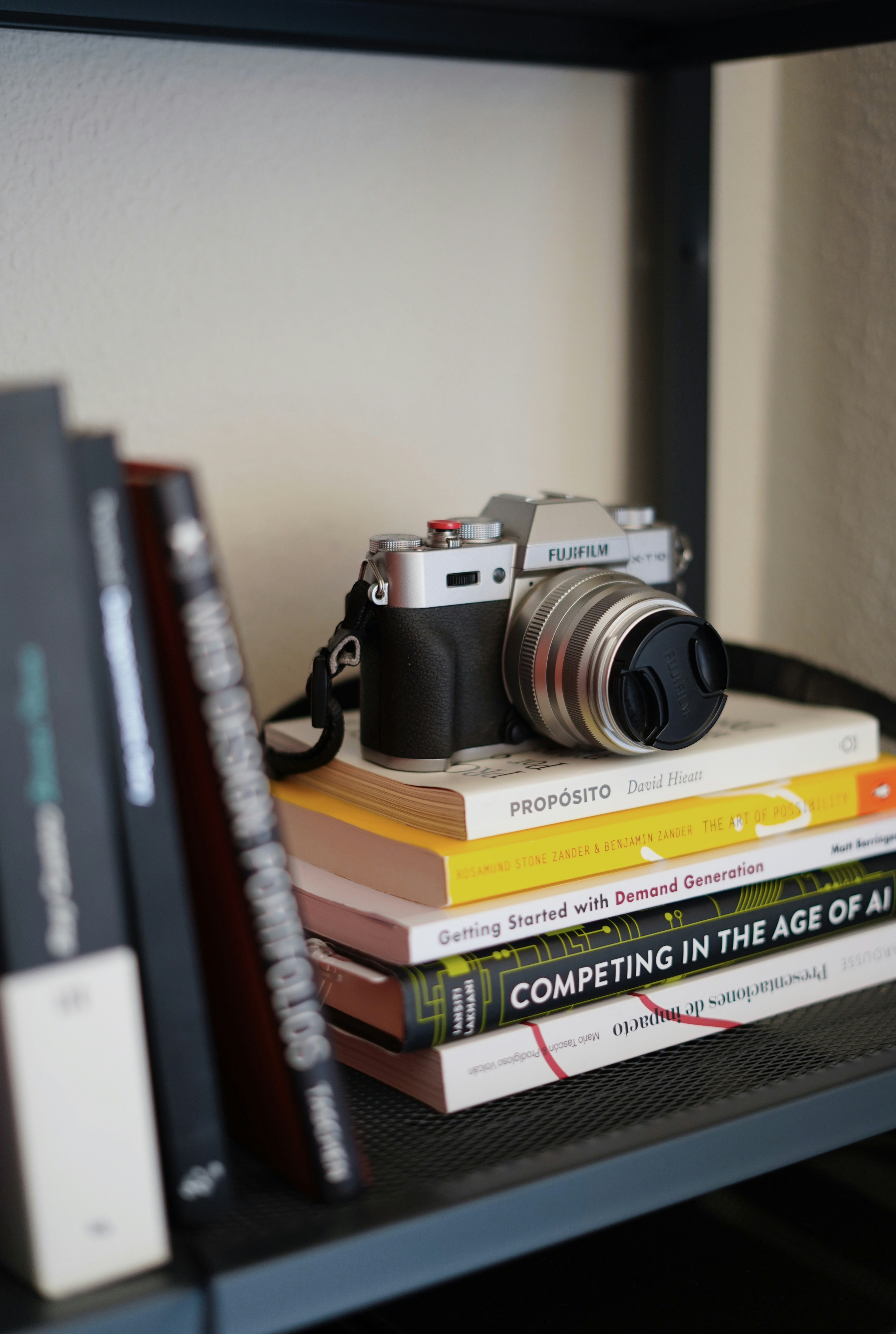 Tower of Knowledge: A Silver Fujifilm Camera Perched on a Stack of Books