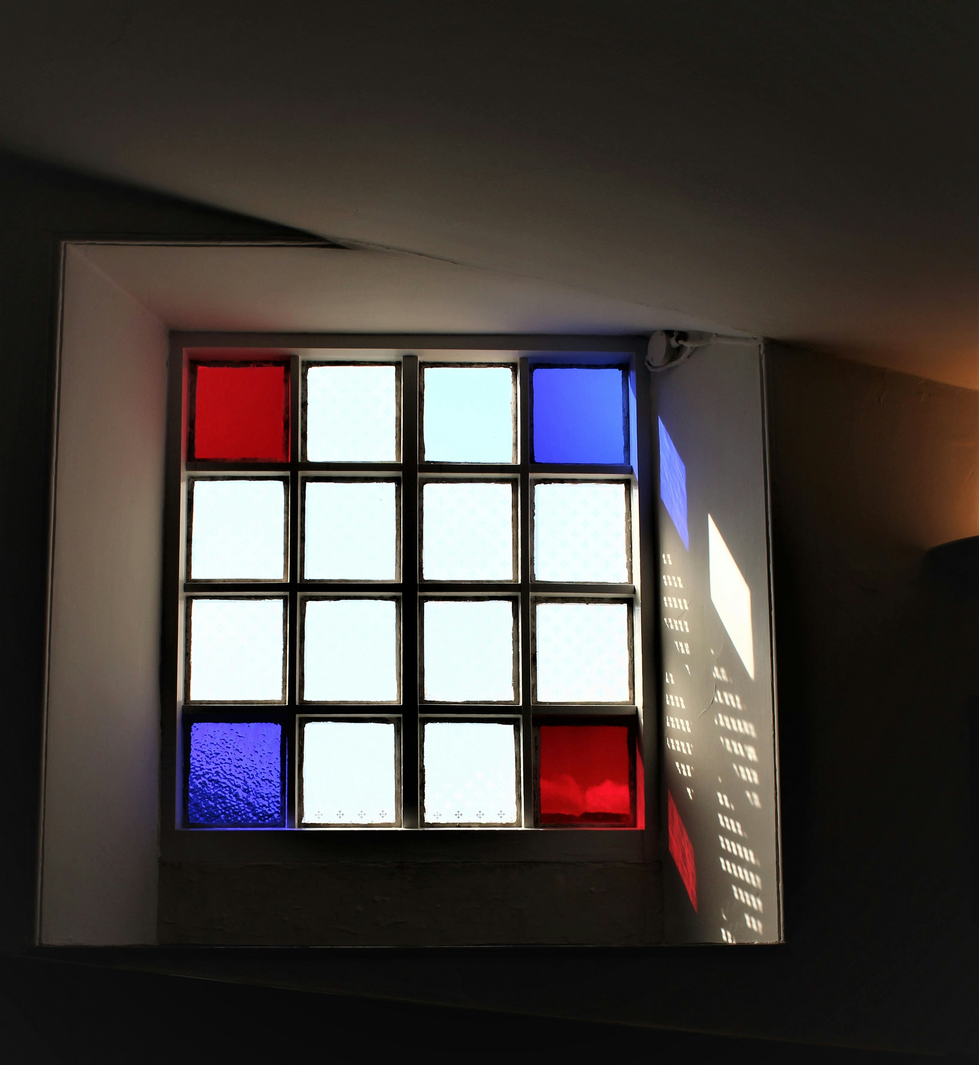 Shadows from sunshine coming through the stained glass window at Belper Unitarian Chapel, UK