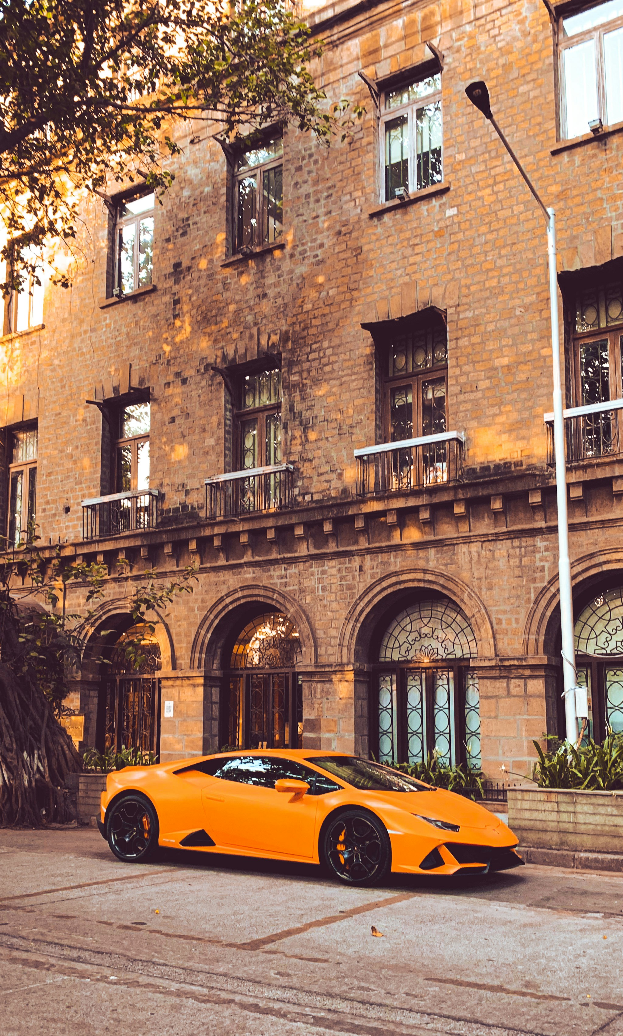 a yellow sports car parked in front of a building