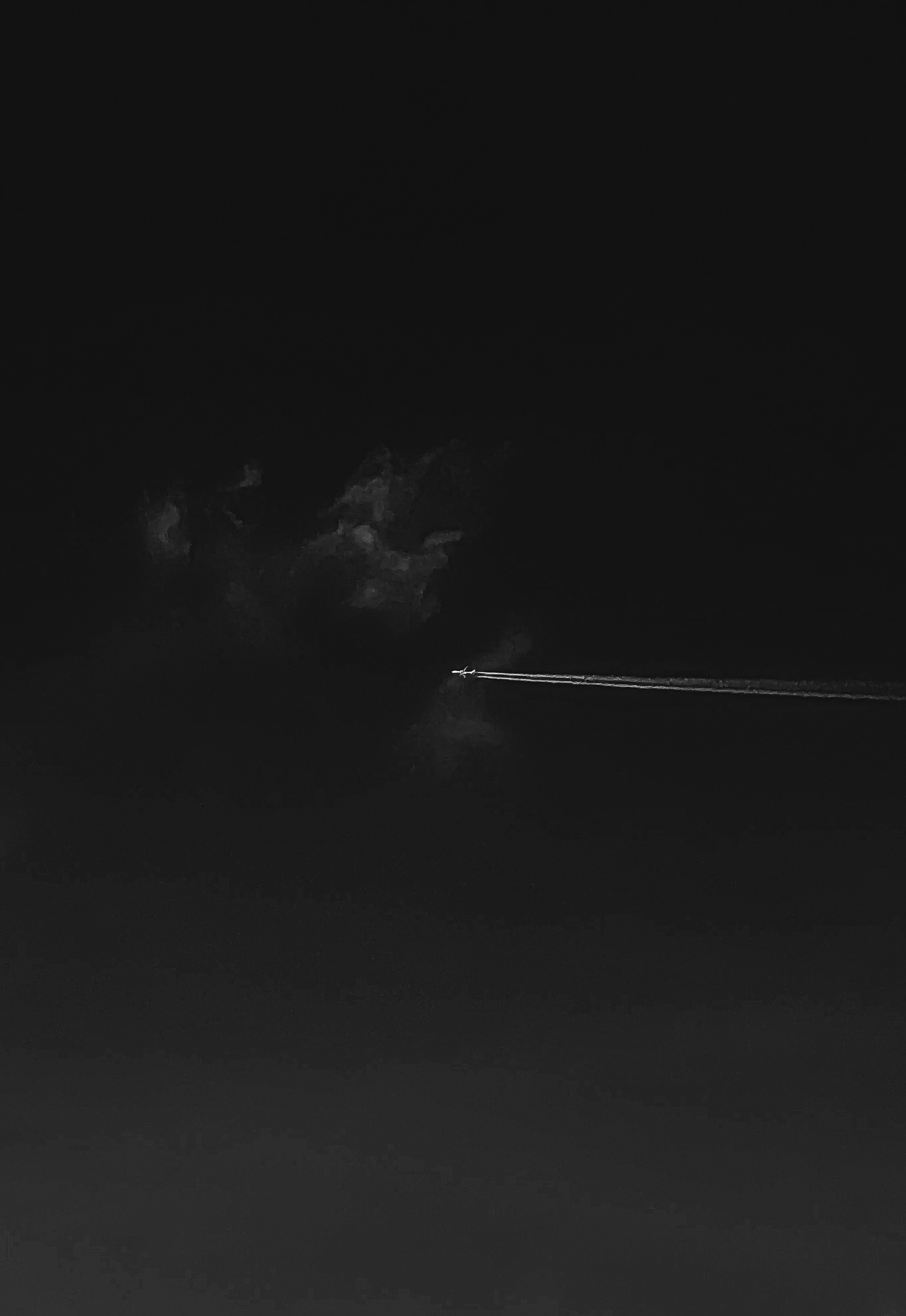 BW of a plane in the middle of the sky