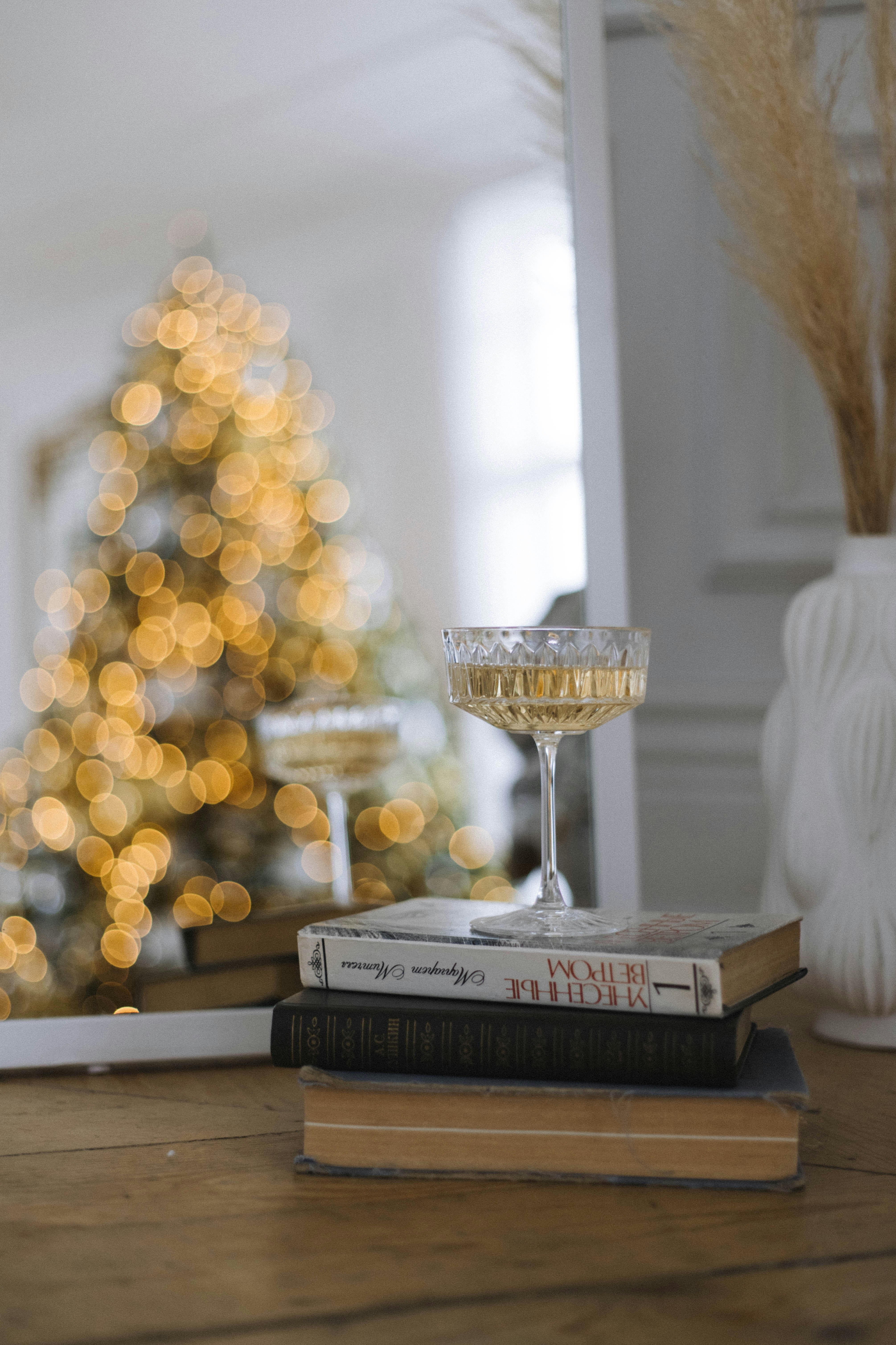 Champagne Glass on Timeworn Books Amid Festive Bokeh