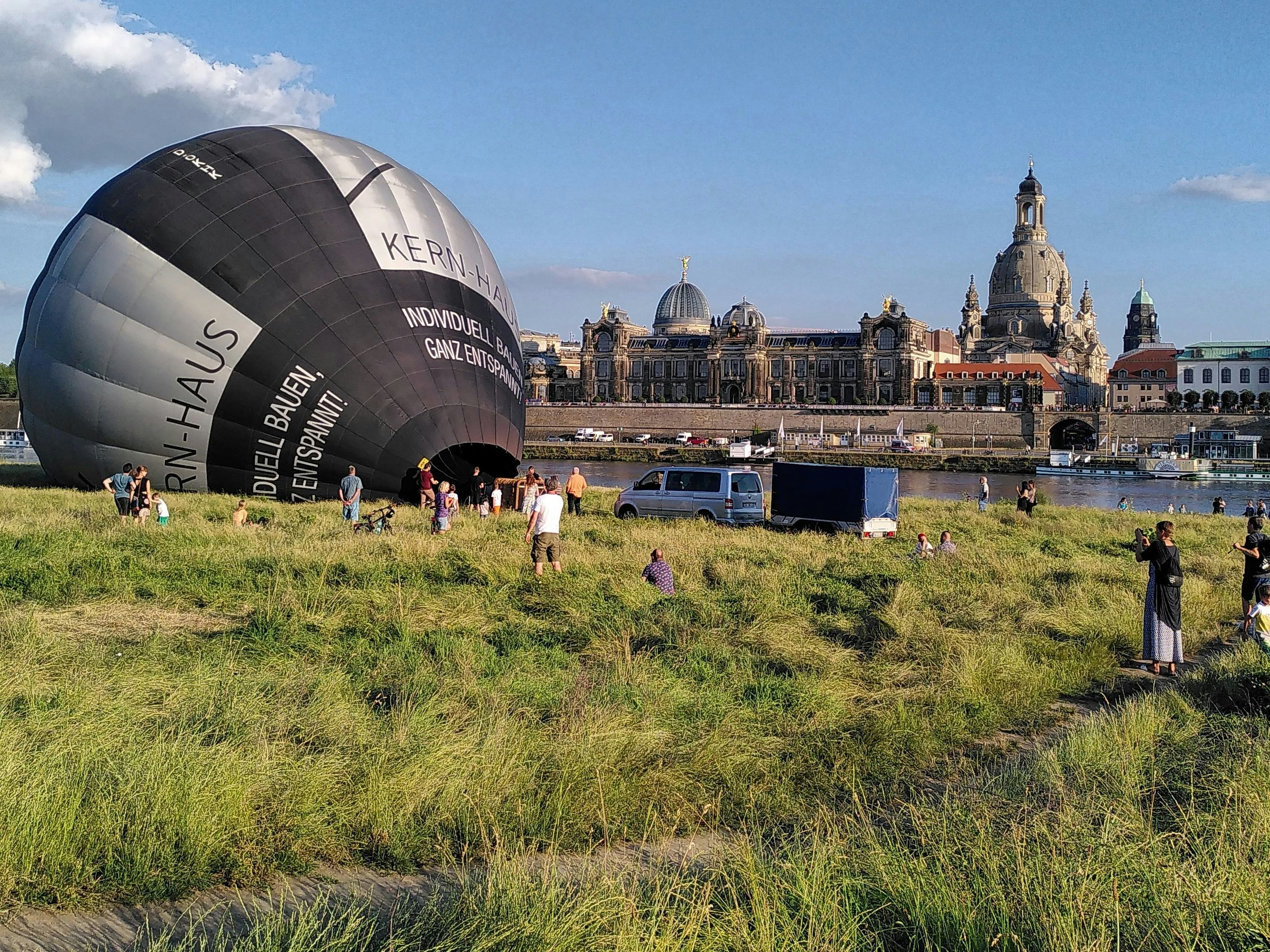 Baloon start on the Elbwiesen in Dresden | a large black and white balloon in front of a castle