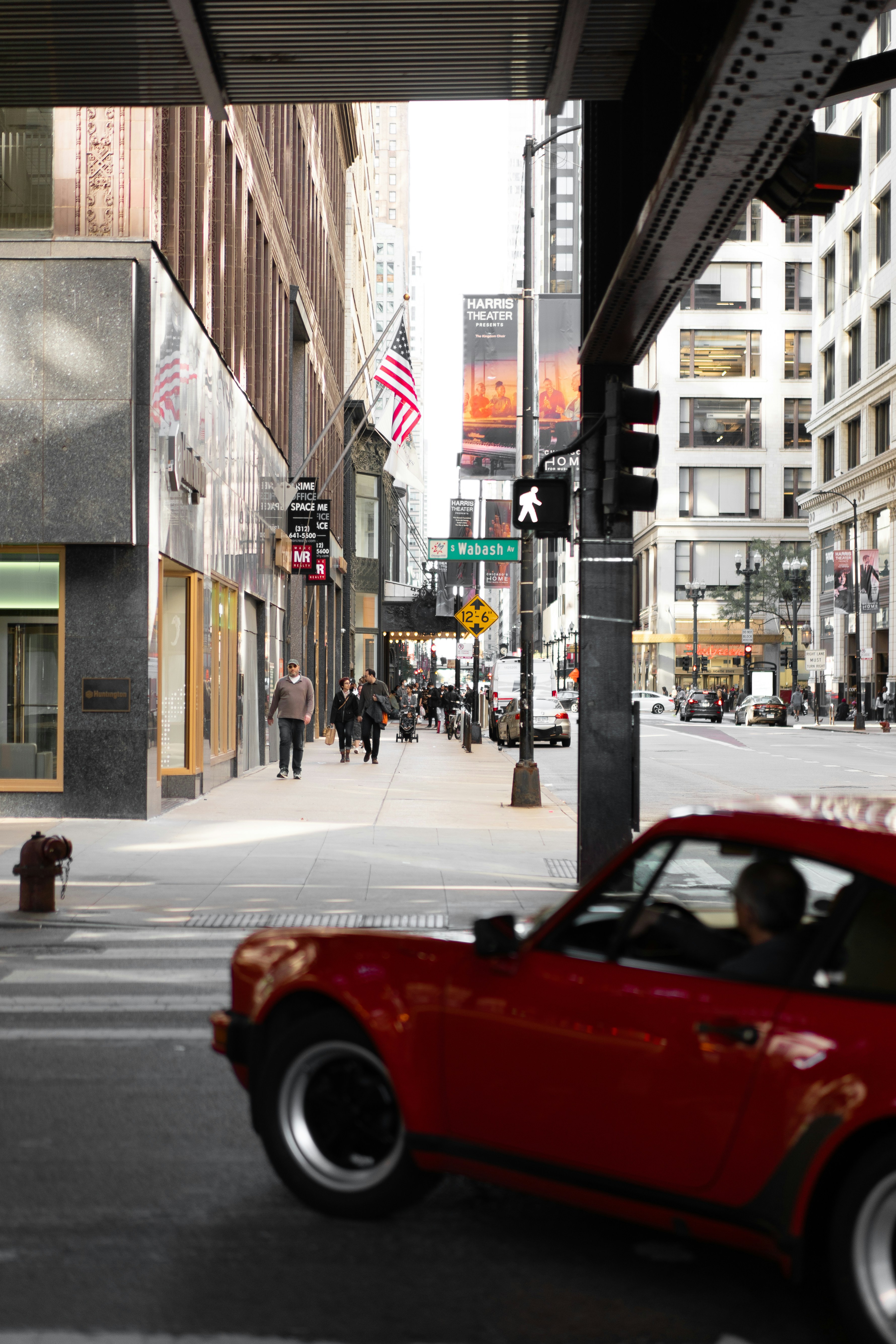 City Pulse: A Red Car Arrives Beneath the Elevated Walkway