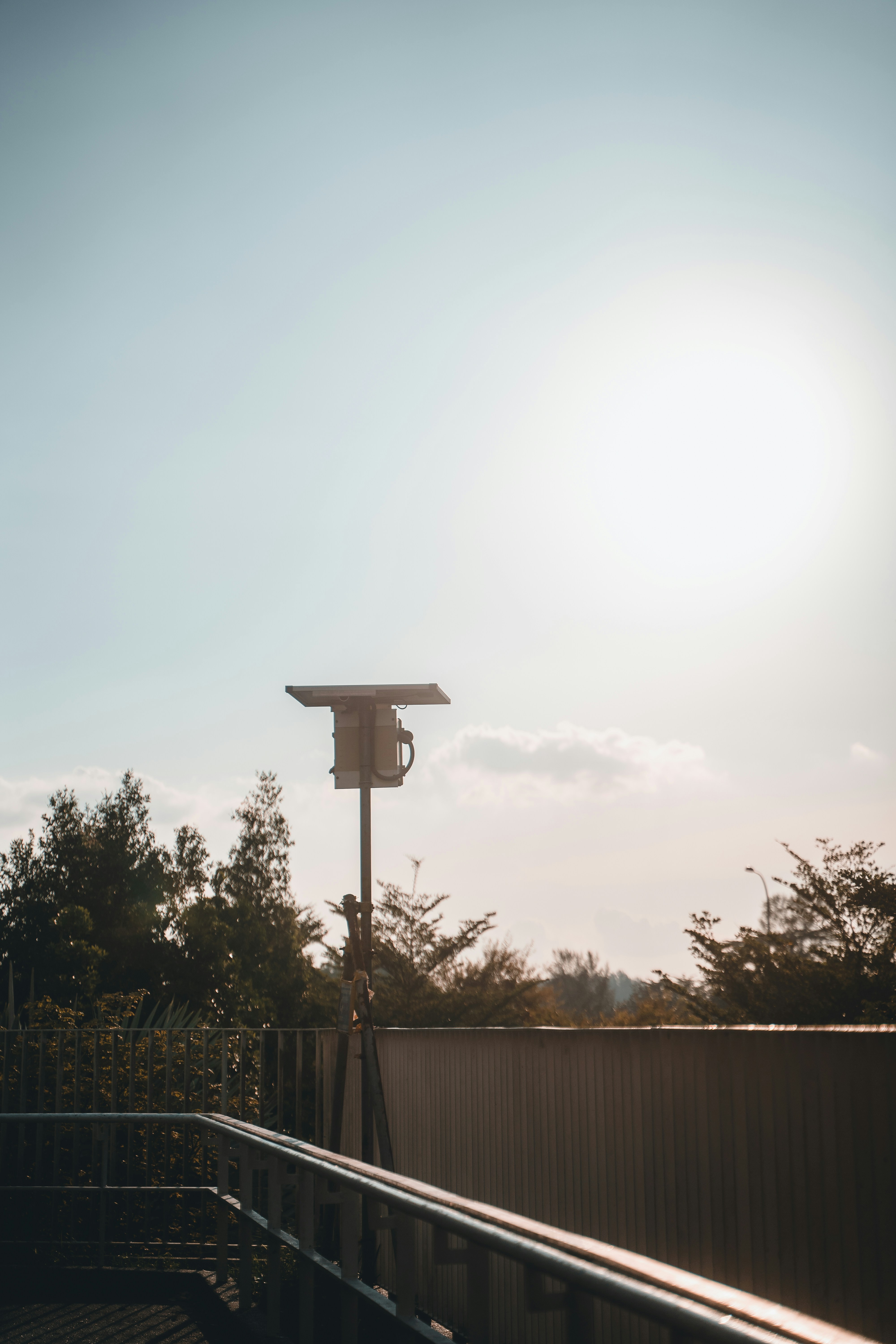 Rooftop Sentinel: A lone solar panel under a bright morning sky