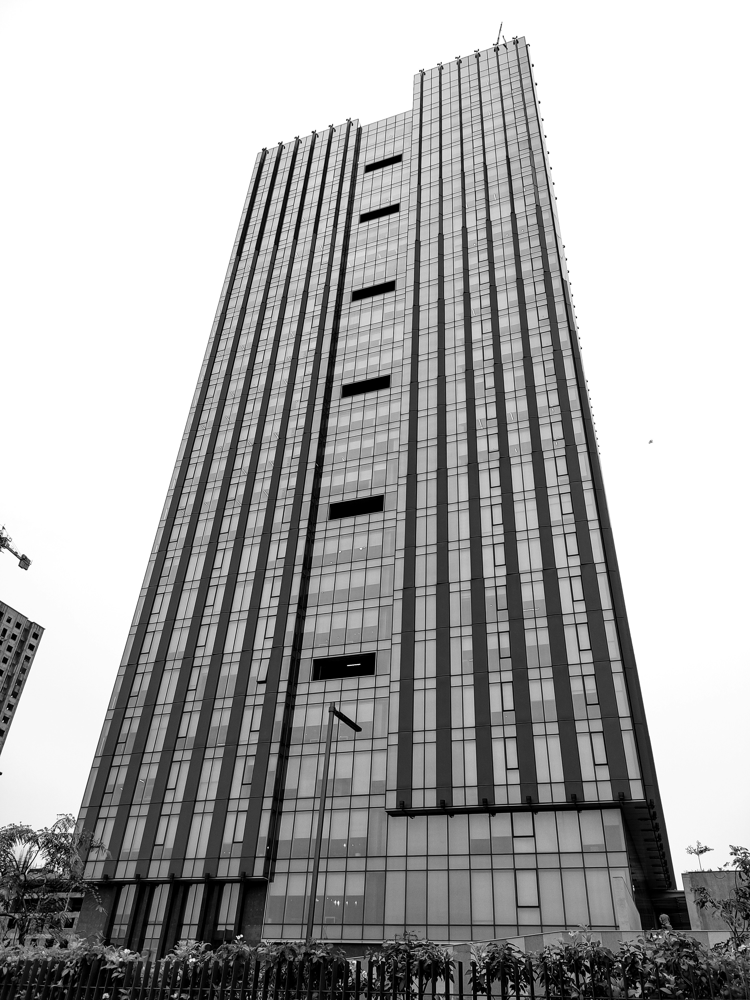 A towering skyscraper with sleek glass and vertical lines, set against a muted sky. The structure embodies contemporary architectural design.