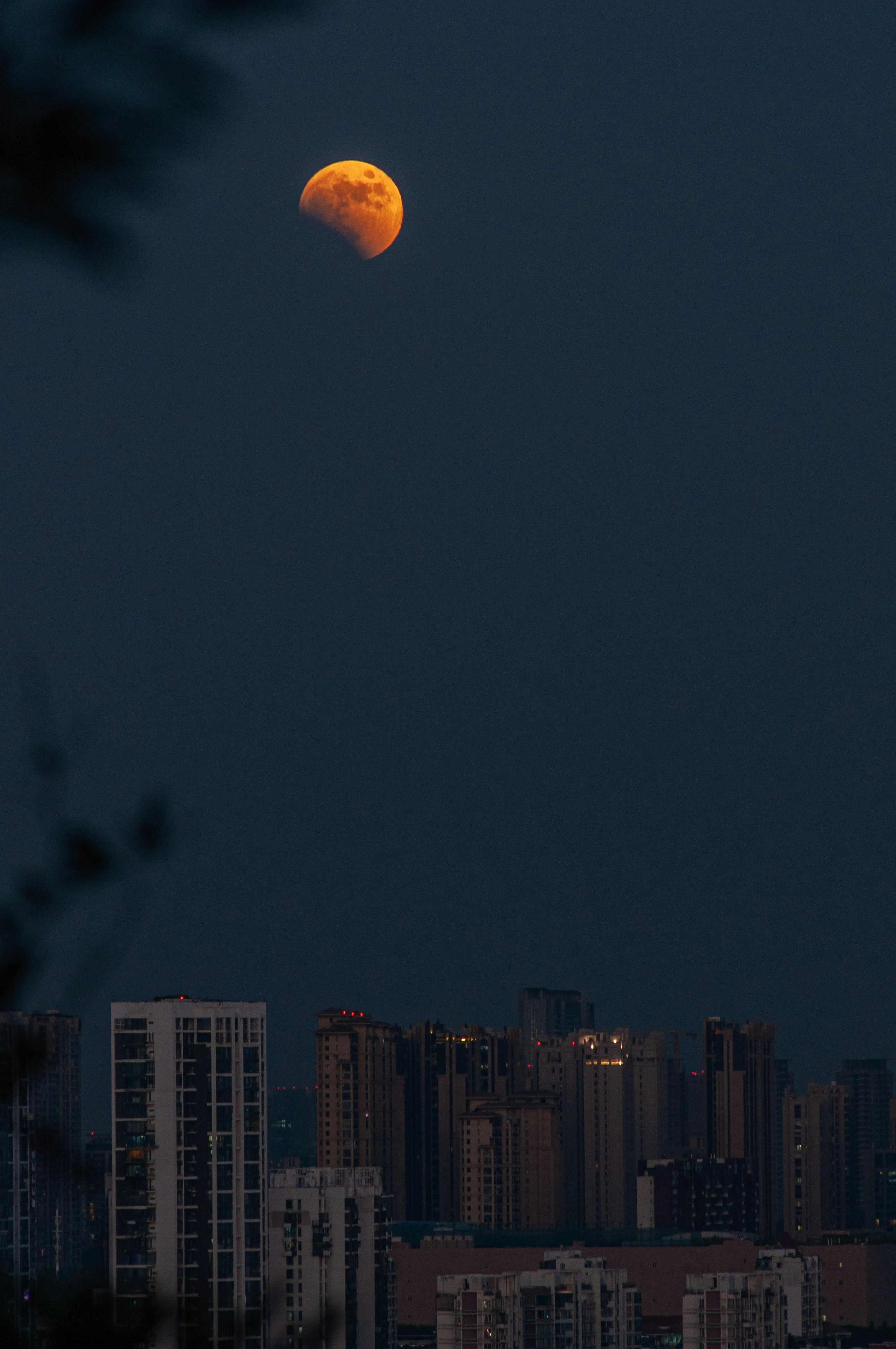 a moon in the sky over a city