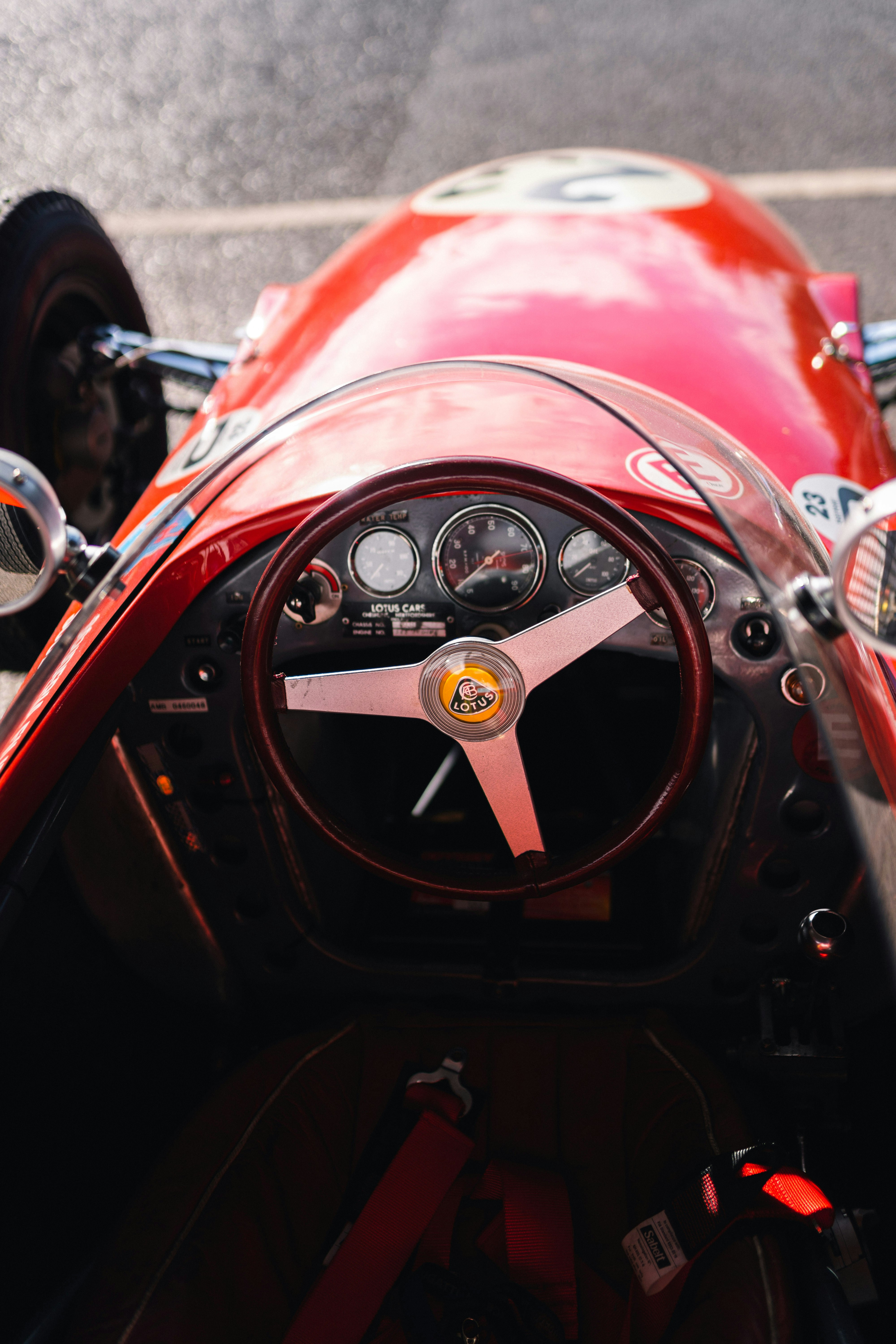 Cockpit of a Red Vintage Race Car: Chrome Three-Spoke Wheel Framing Analog Gauges