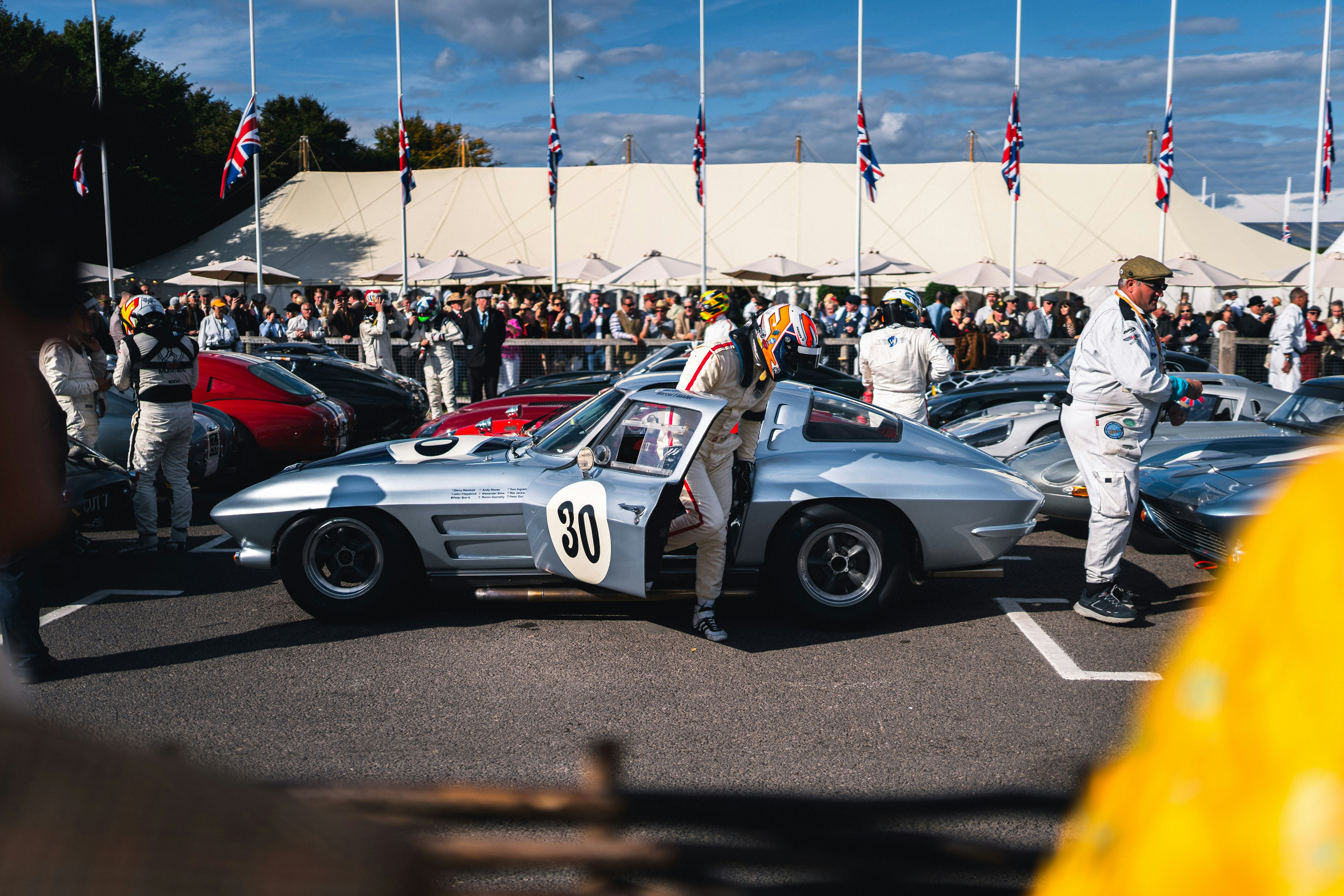 Race-Track Moment: The silver sports car with door open at the paddock