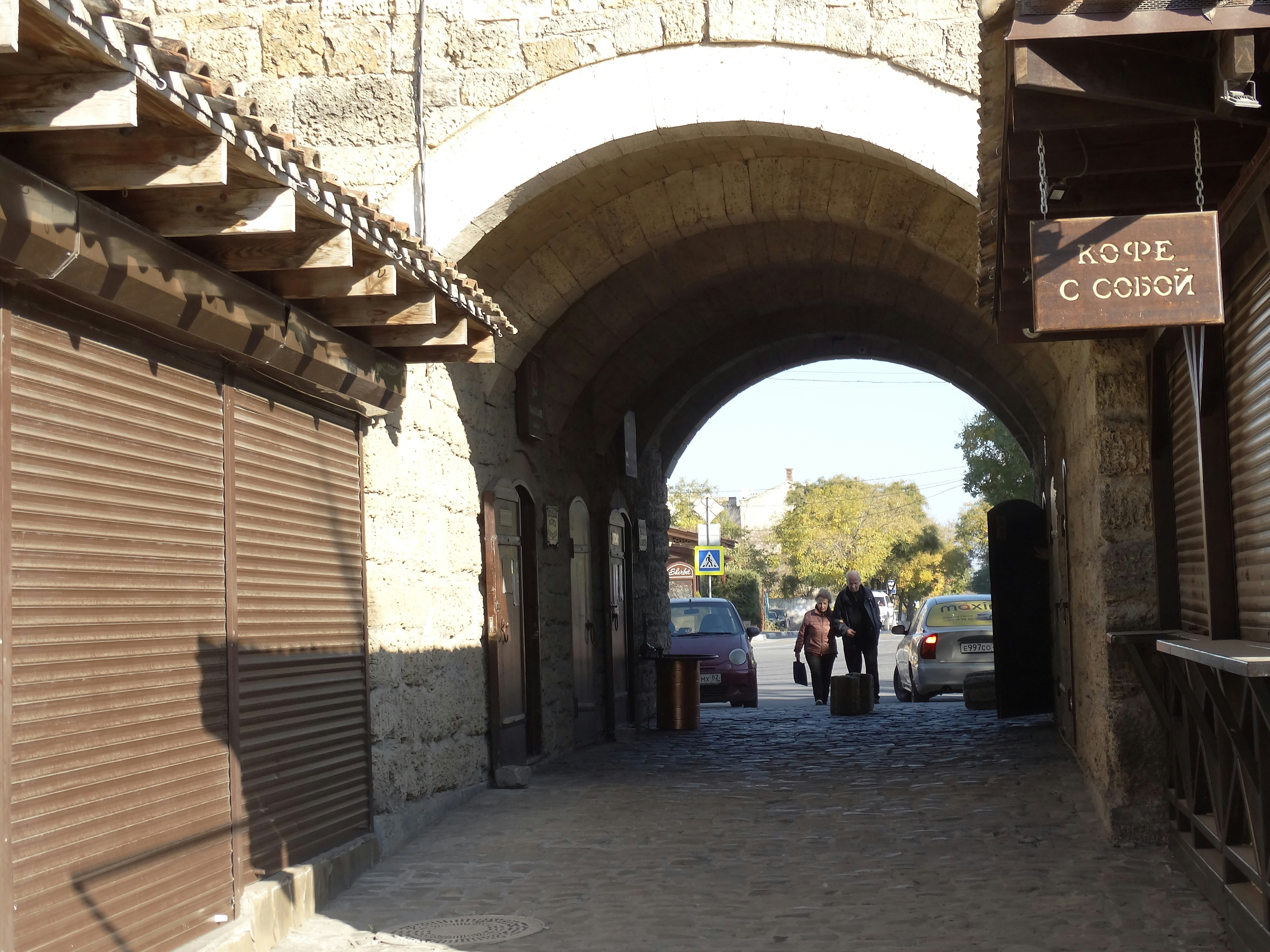 Past the Arch: A Quiet Passage to a Sunlit Street