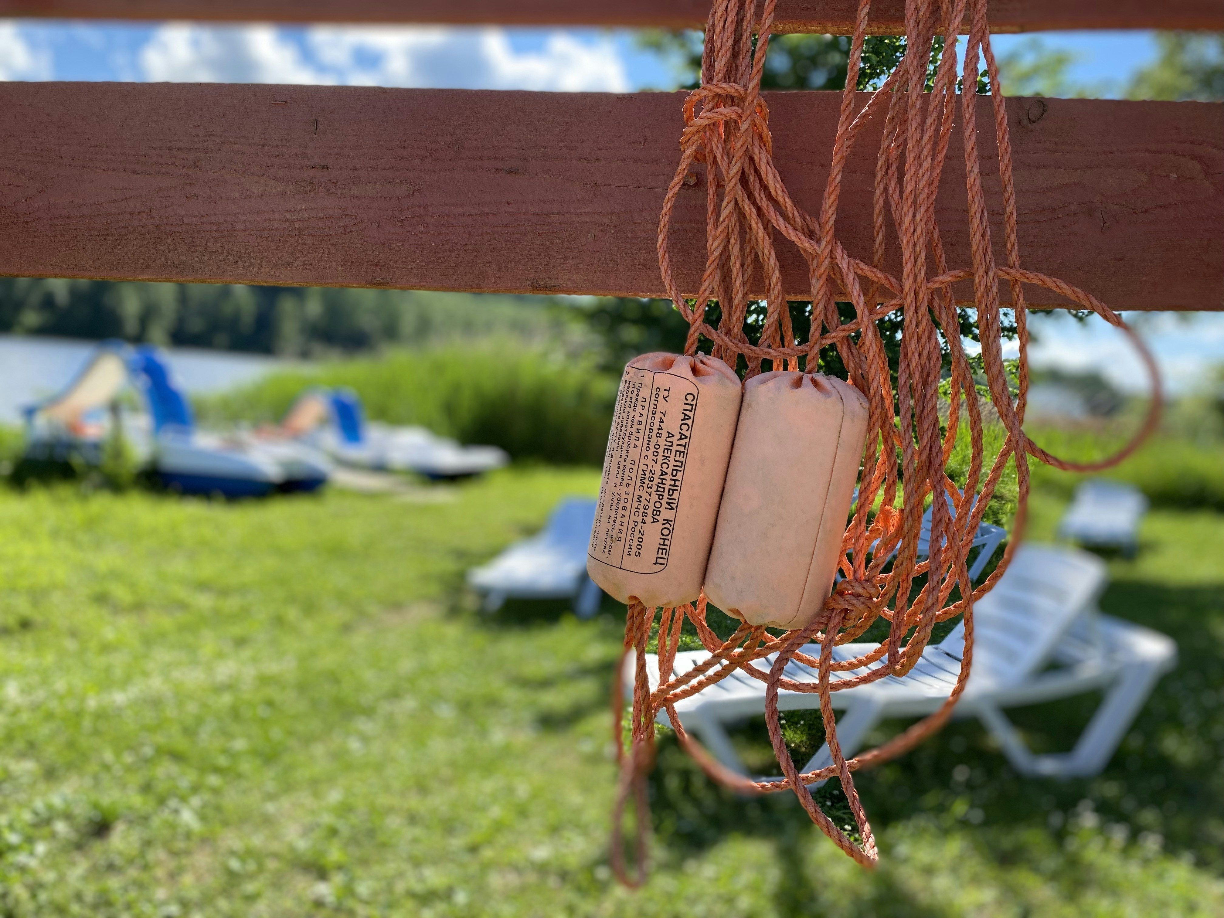 Rope Suspenders: Close-Up on Weathered Floater with Blurred Lawn Chairs