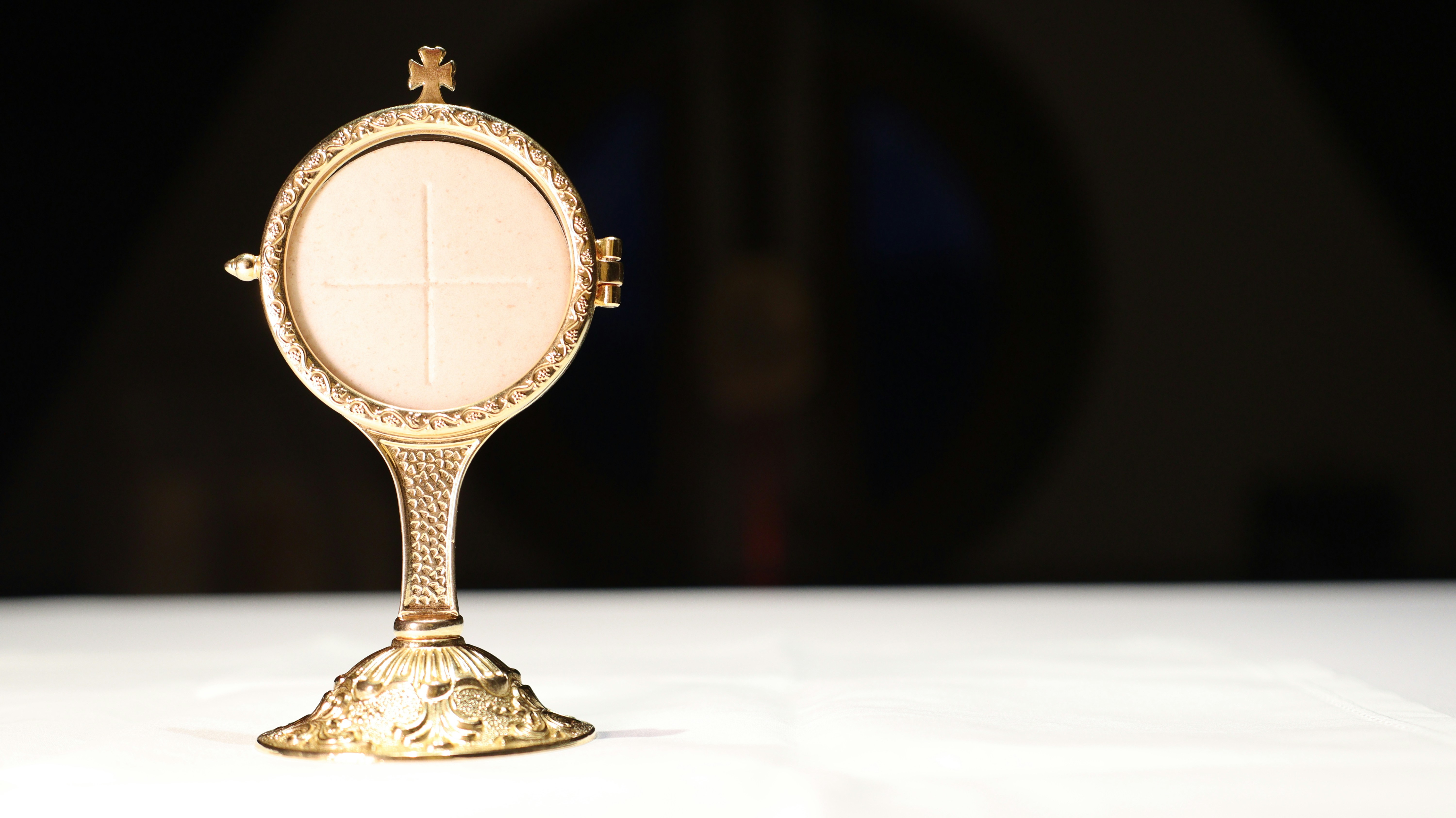 Ornate reliquary on a pedestal: a lone ceremonial piece in a dim setting