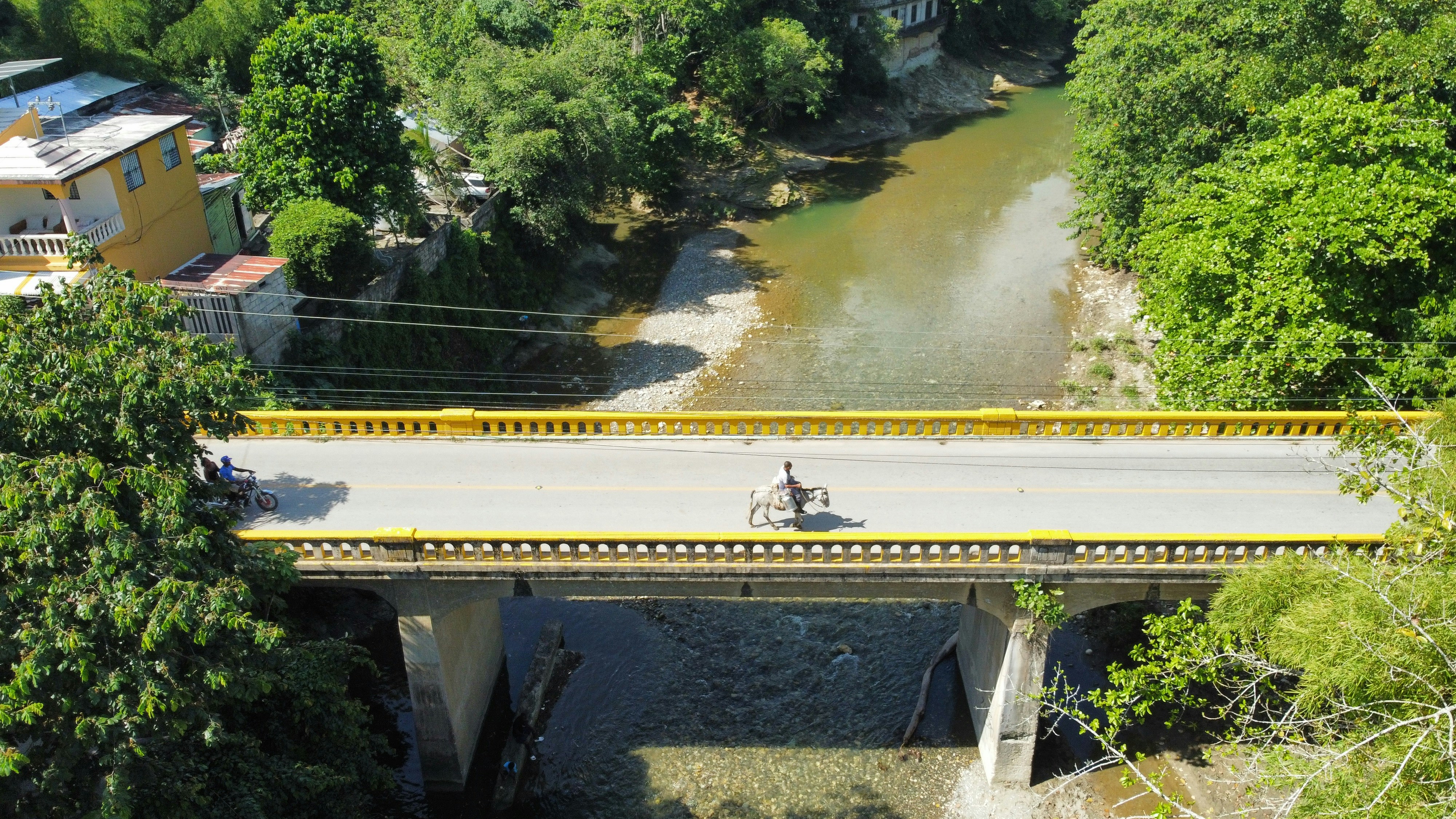 A person riding a motorcycle on a bridge over a river photo – Free ...
