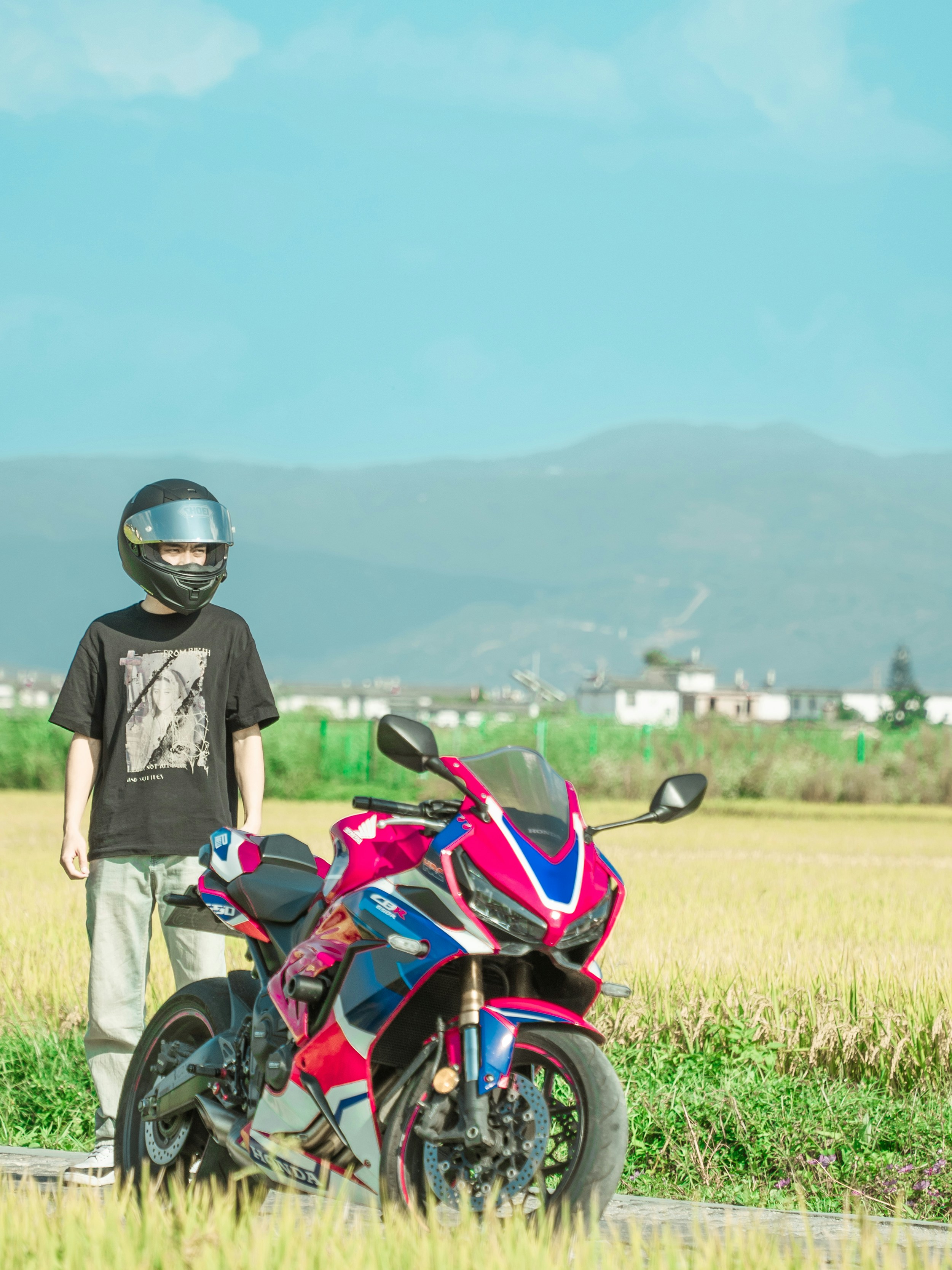 Neon Mirage: Rider Beside a Pink-Blue Sportbike in a Quiet Field