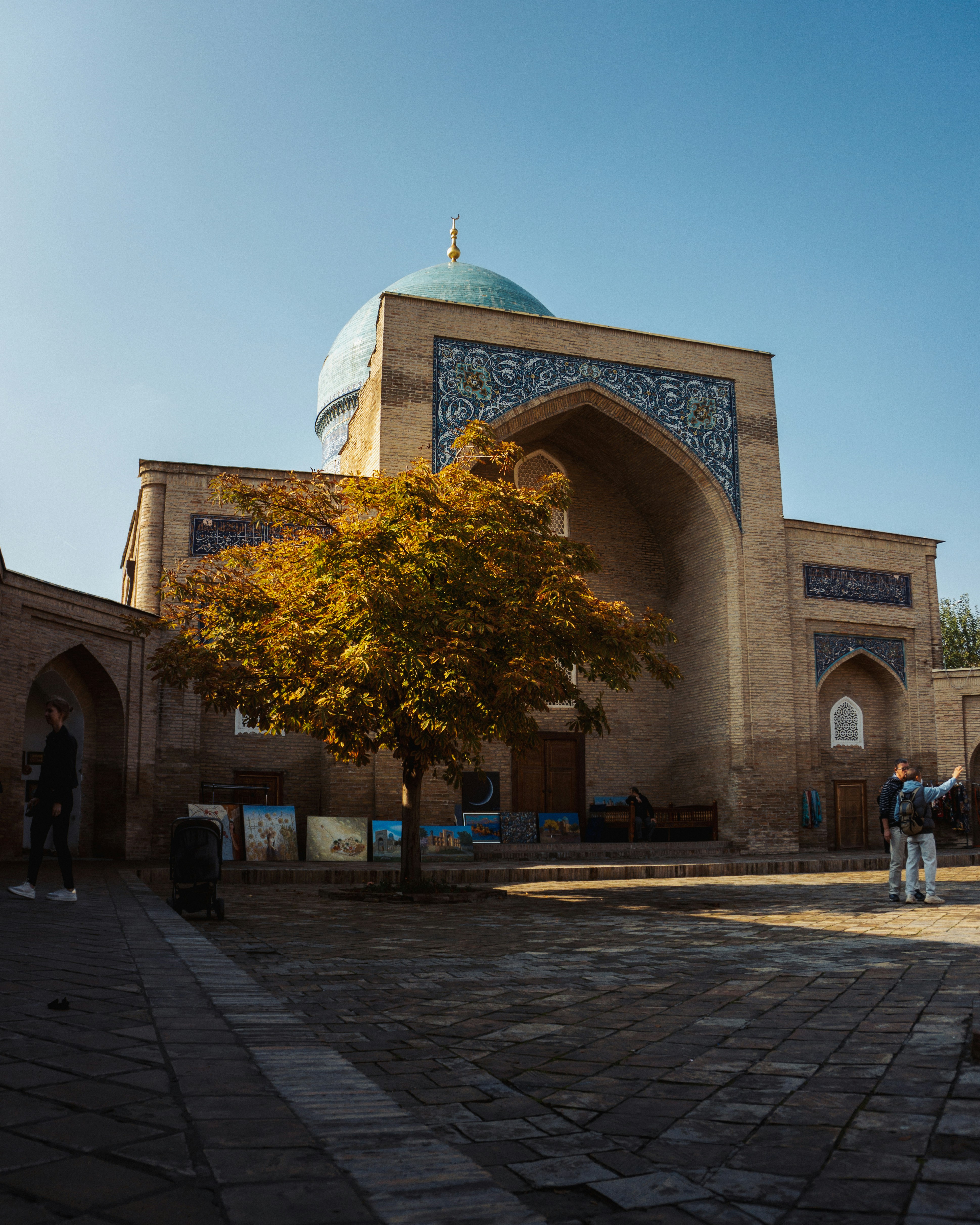 Autumn Light Framing a Blue-Domed Gateway in a Tile Courtyard