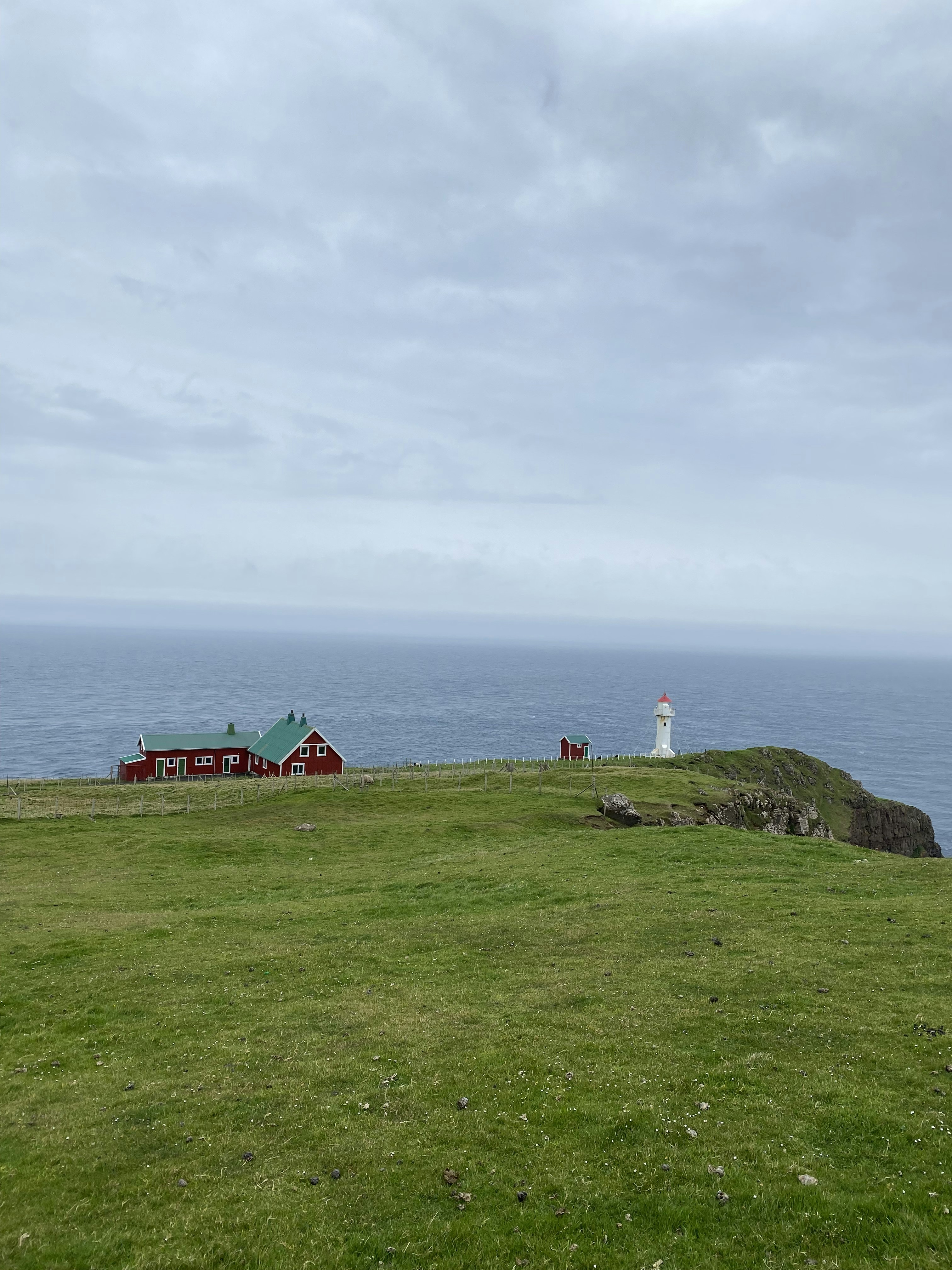 A lighthouse on a grassy hill by the water photo – Free Faroe islands ...
