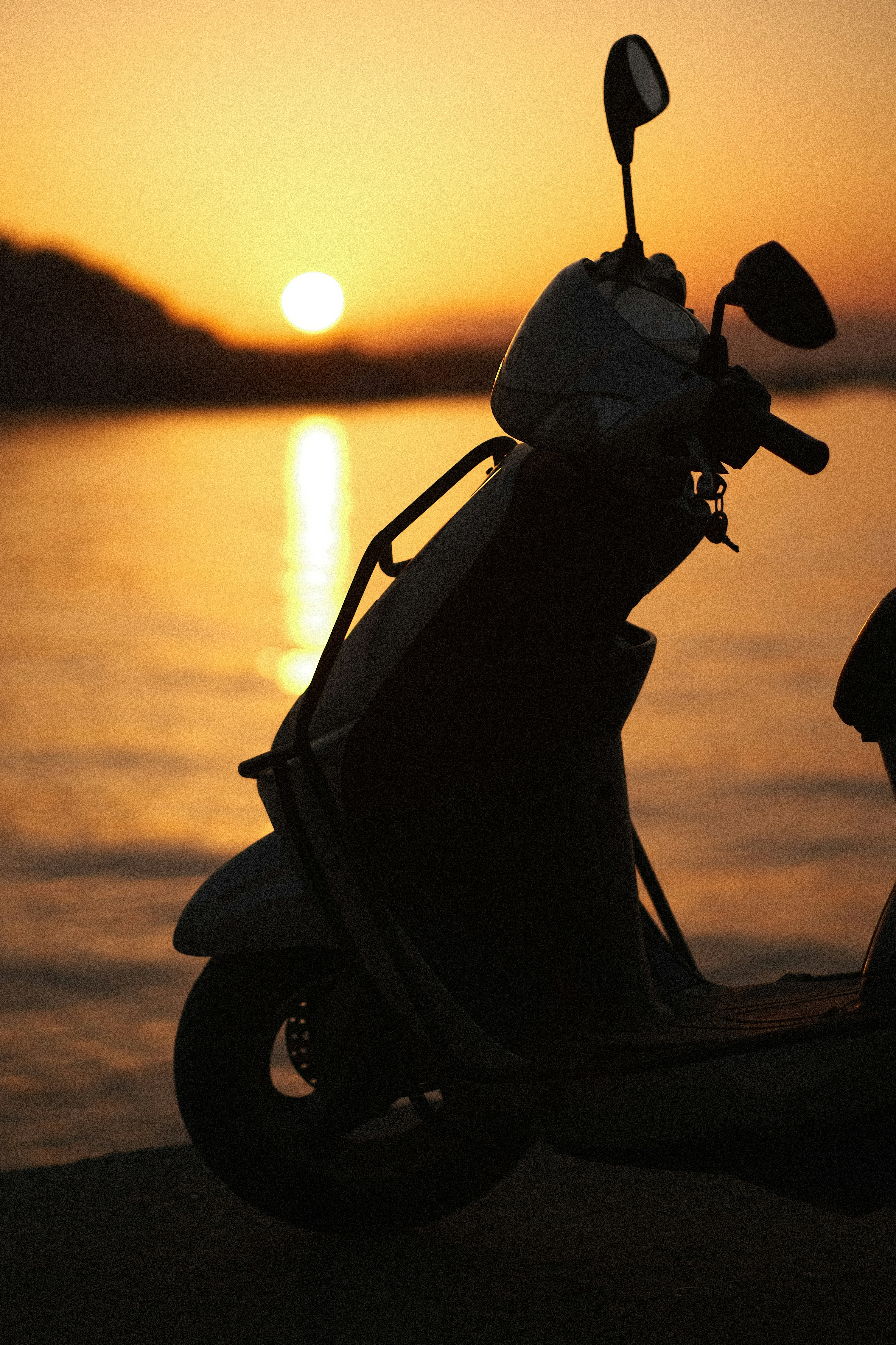 Horizon Rider: Sunset Silhouette of a Scooter at Dusk