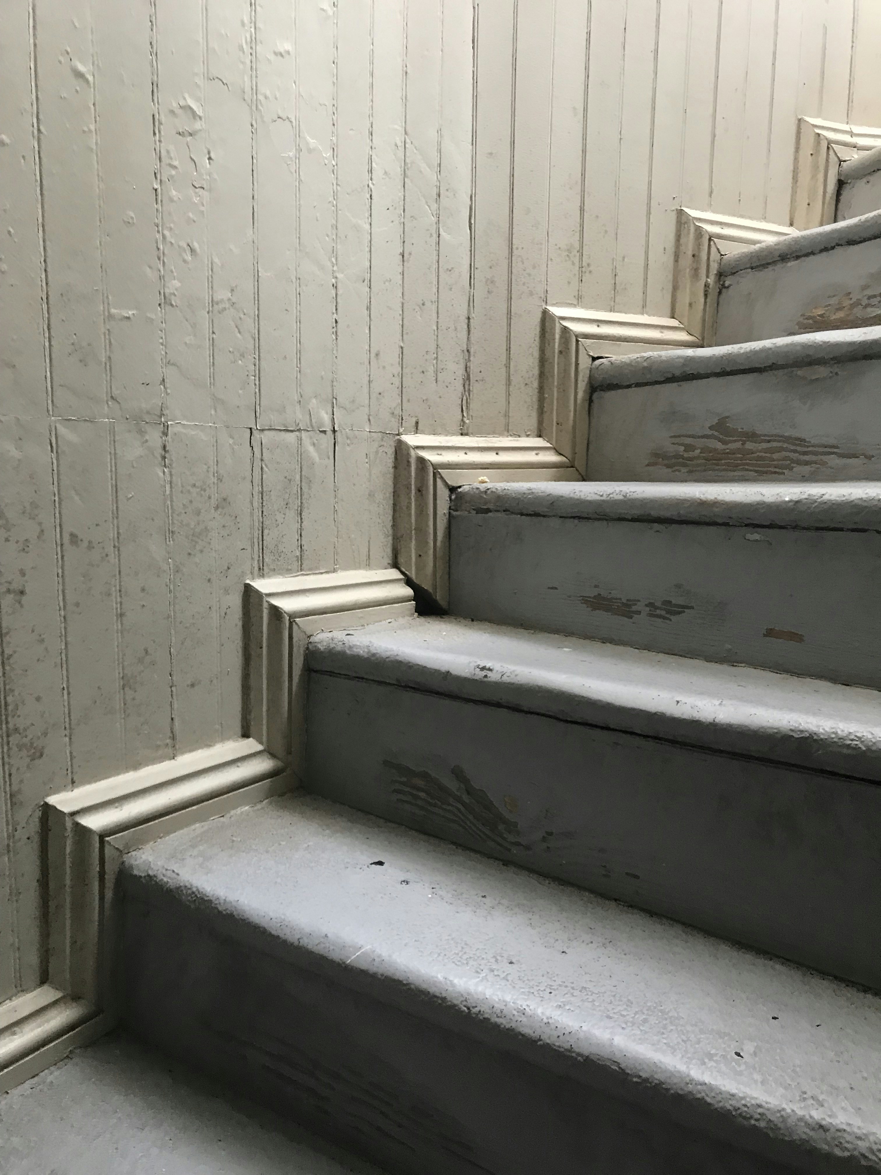 Close-up view of weathered concrete stairs leading upwards, showcasing intricate details of the surrounding wall and stair edges.