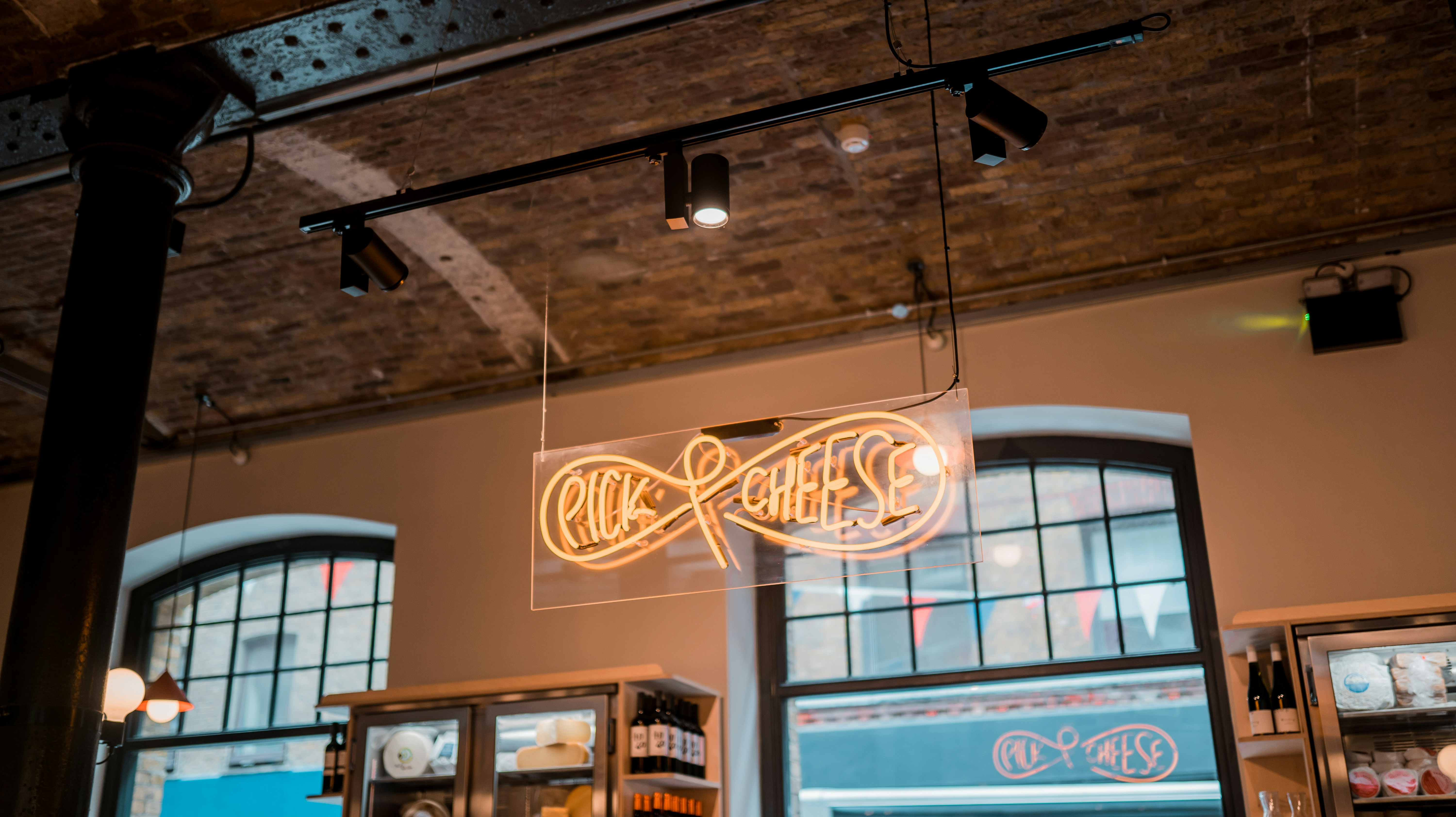 Neon Cafe Logo Glows Over Industrial Interiors