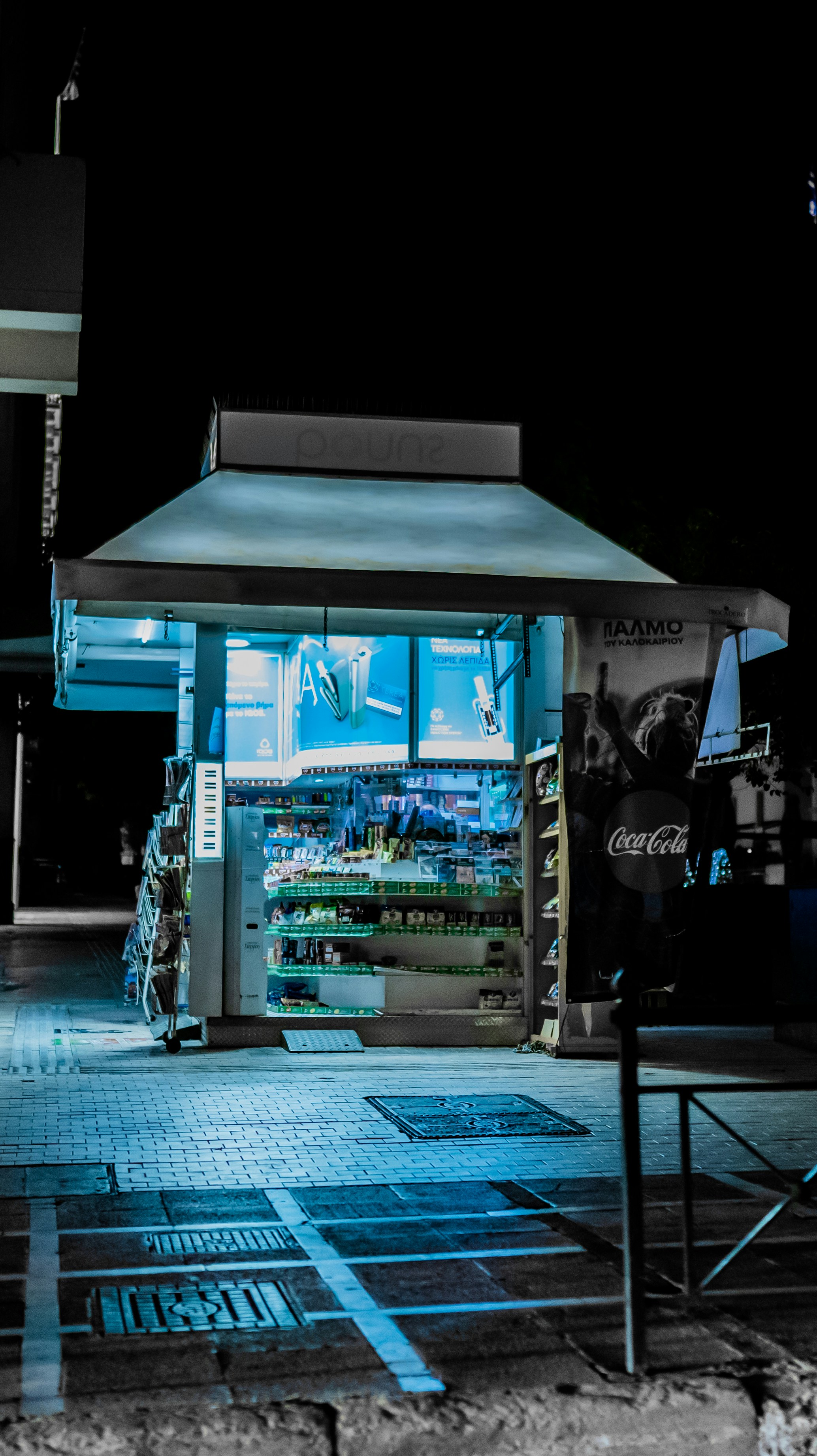 Blue Neon Facade: Night Cashier Stand Illuminated in Quiet Street