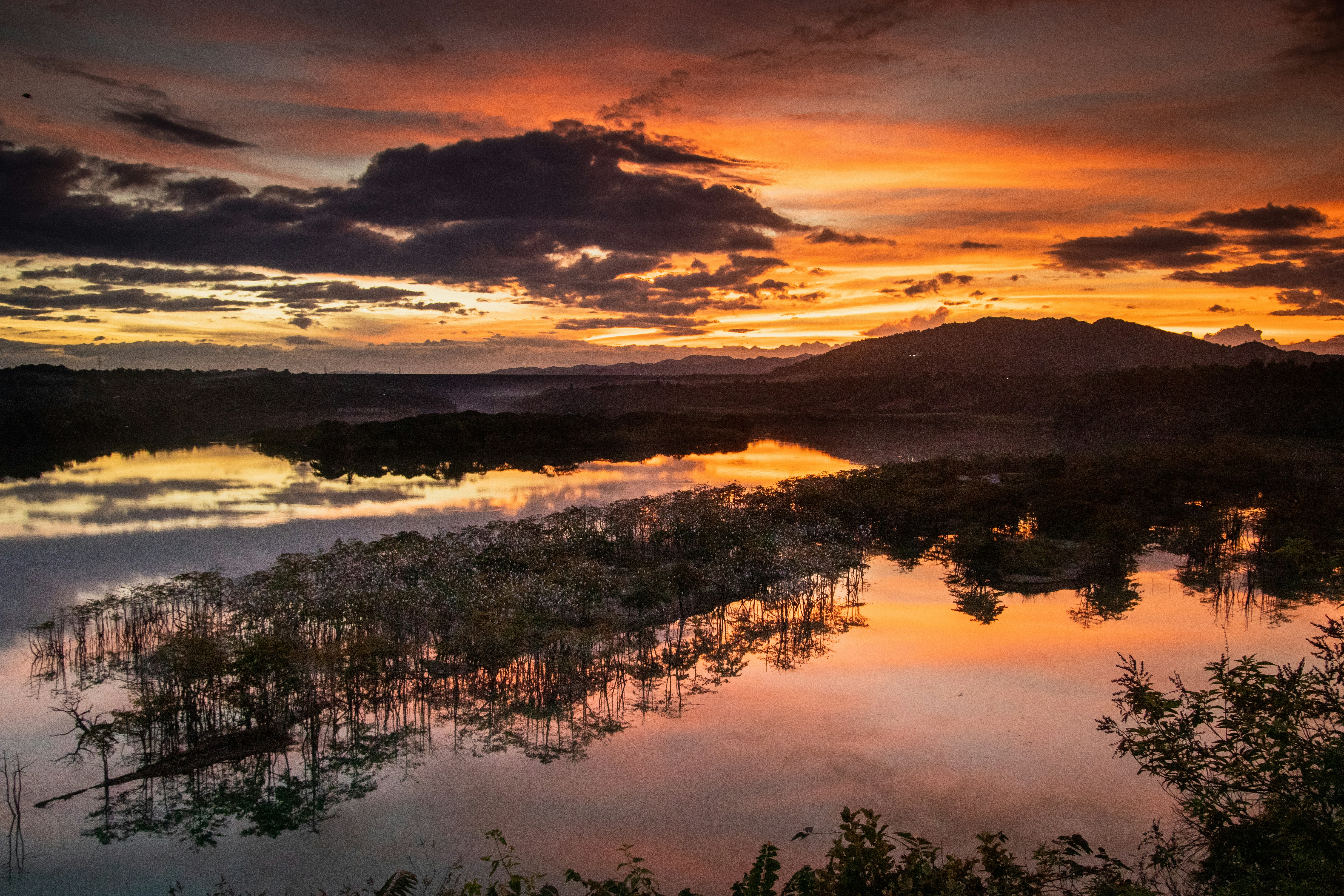 Foto Un cuerpo de agua con árboles y montañas al fondo – Imagen Alfonso ...