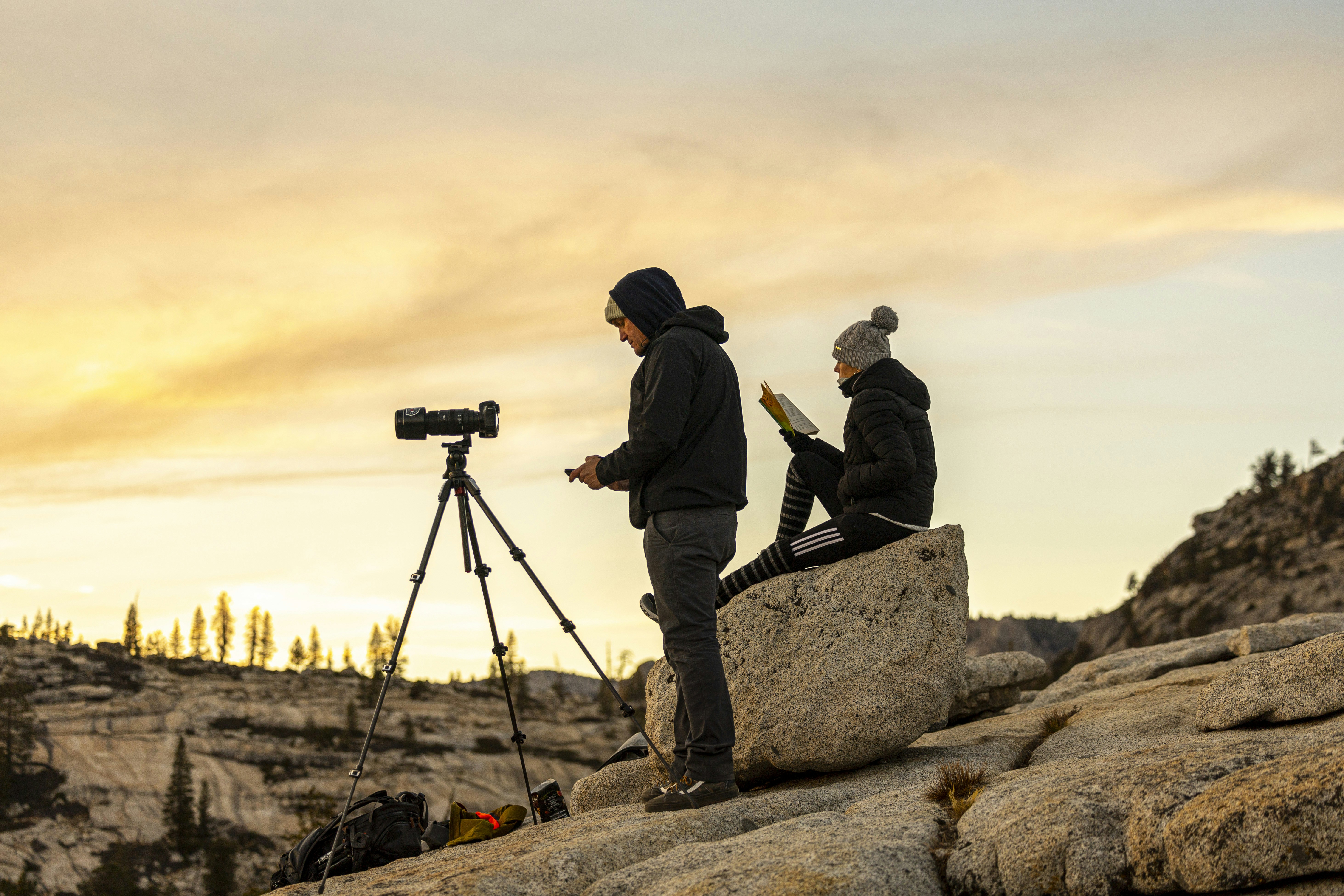 Sunset Canon: Two explorers on a sunlit granite overlook