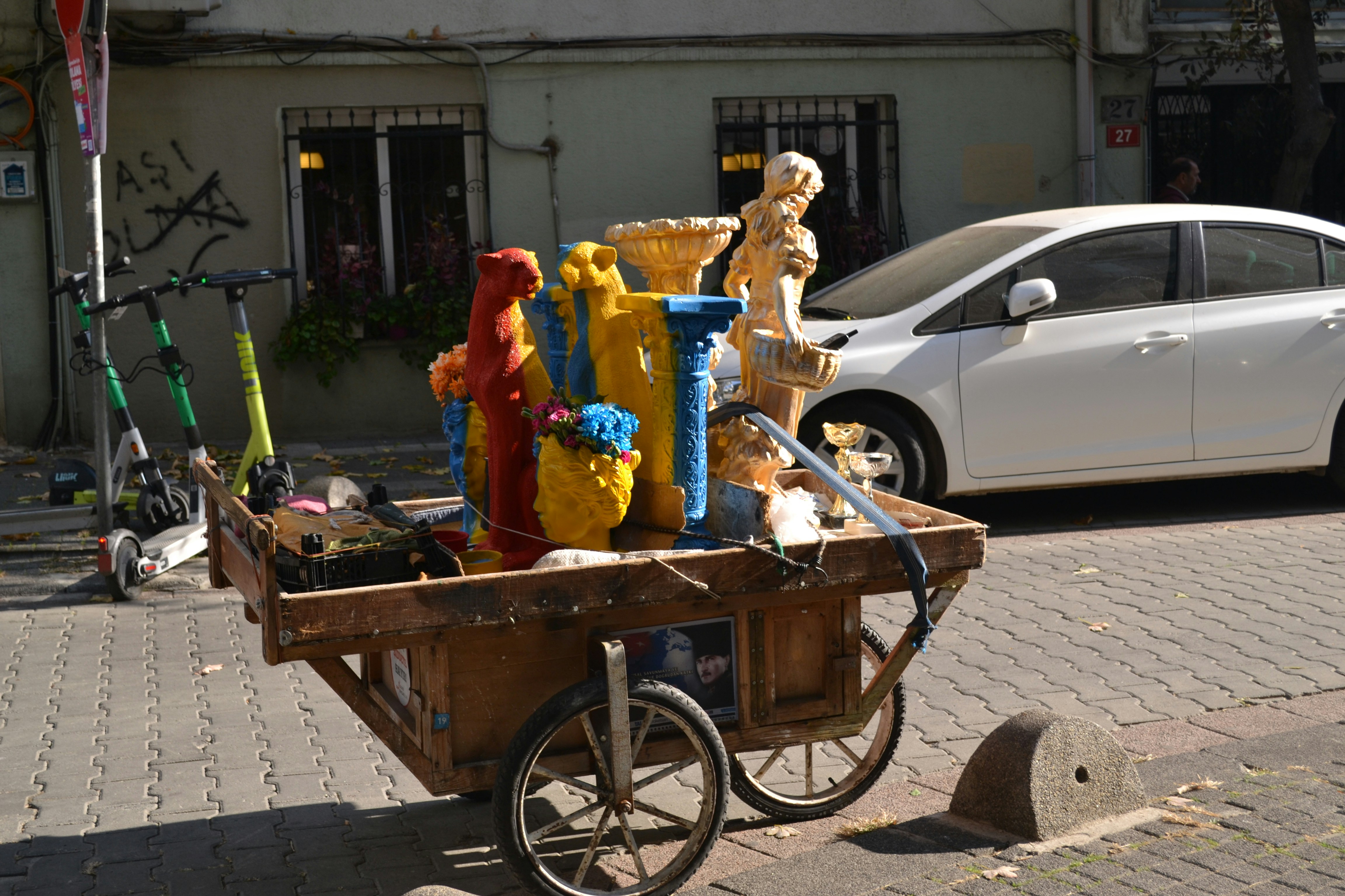 Sunlit Street Cart of Colorful Busts
