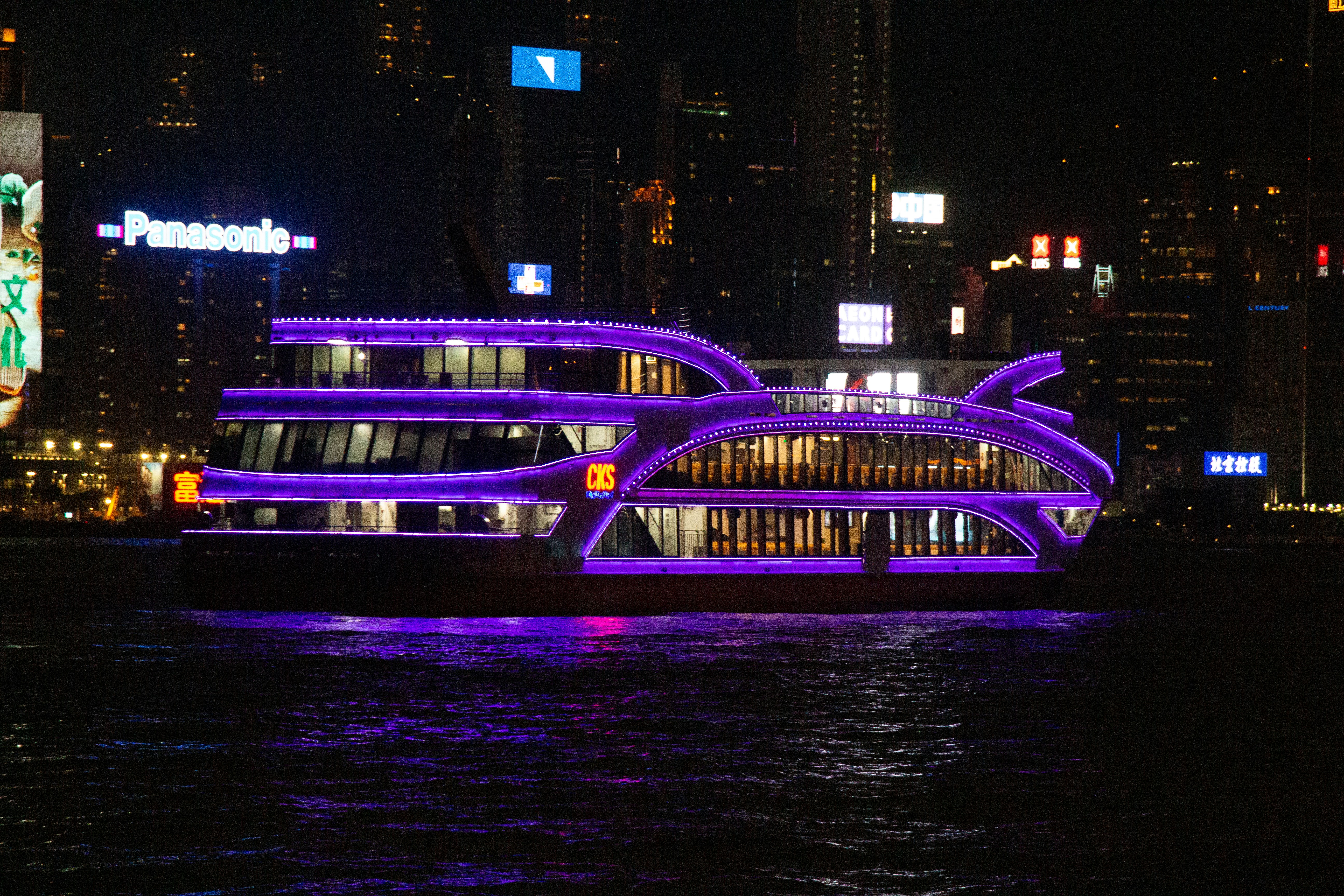 Neon Crescent Night Cruise: A Purple-Lit Vessel Among Skyline Lights