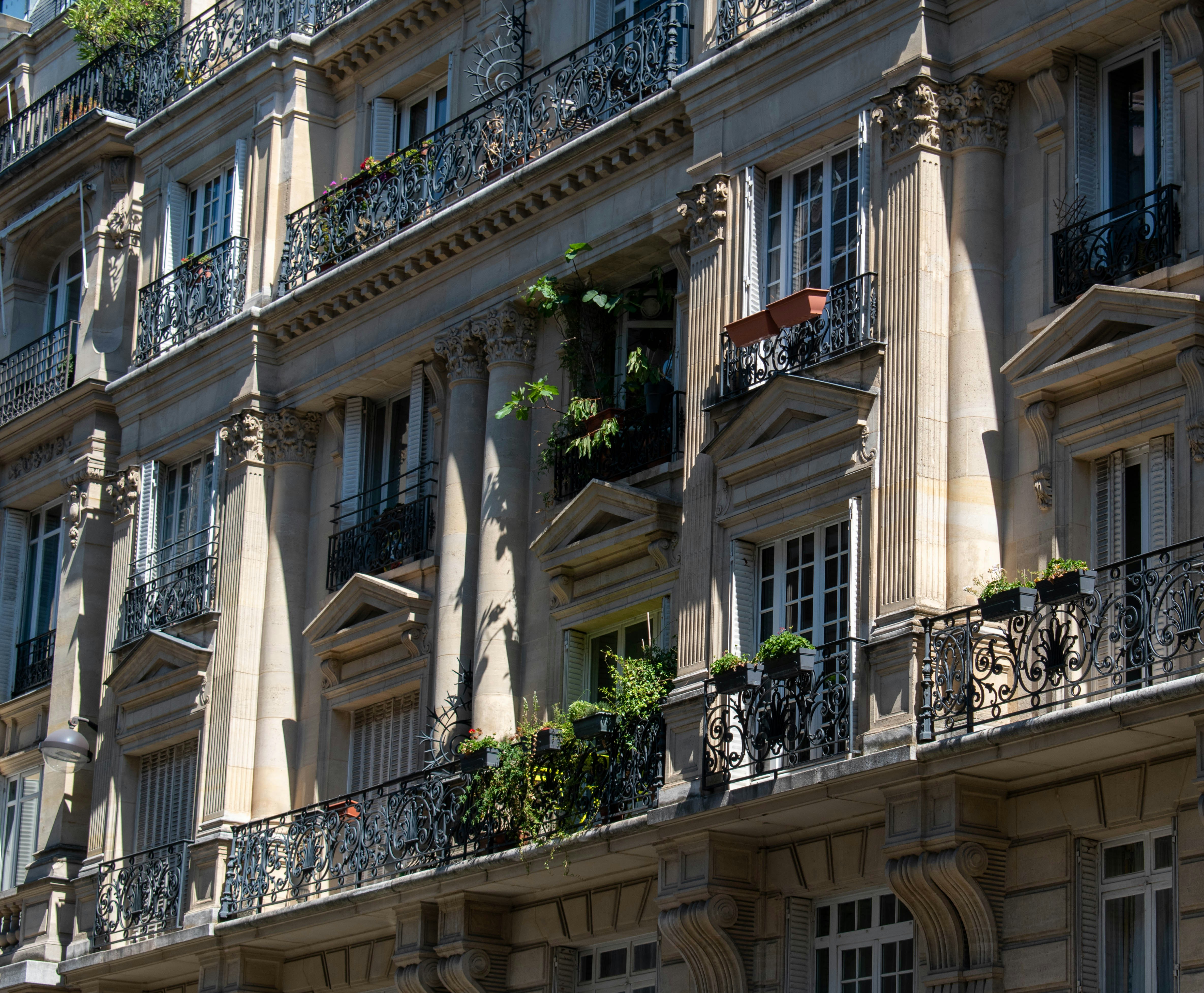 Foto Un edificio con balcones y plantas en las ventanas – Imagen París gratis en Unsplash
