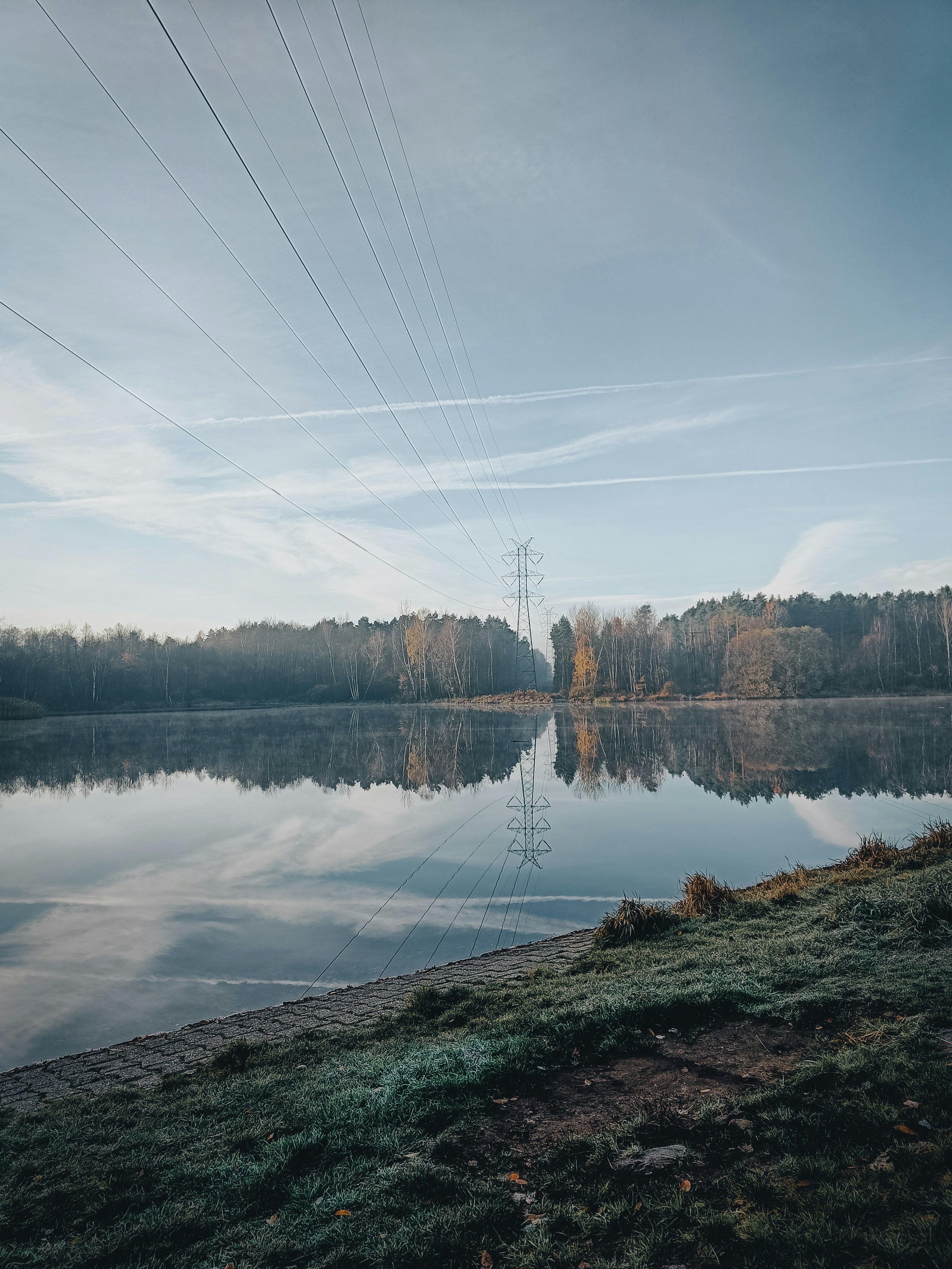 Mirror-Lined Riverbank Under Power Lines
