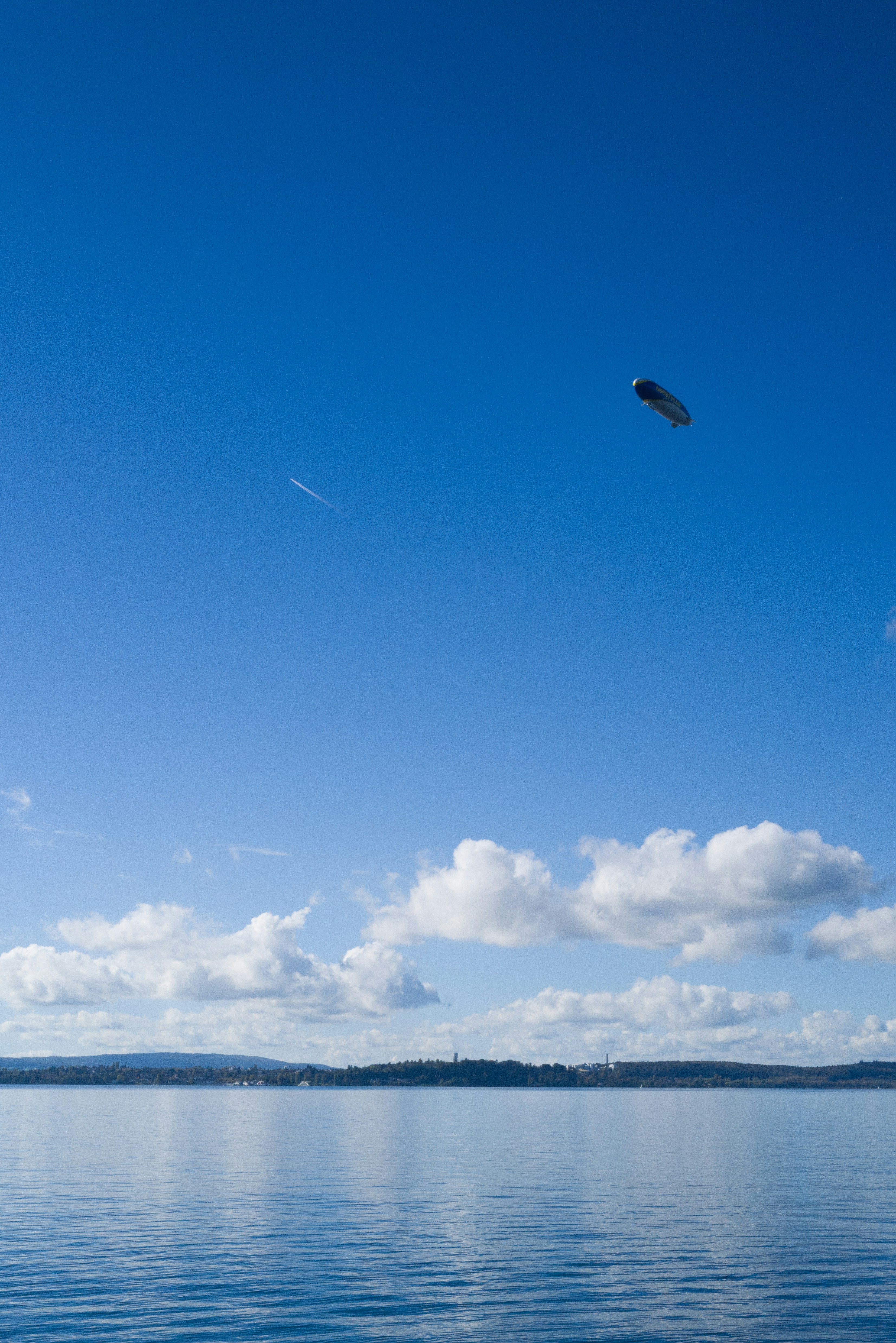 Distant Glider Over a Quiet Lakescape in a Crystal Blue Sky