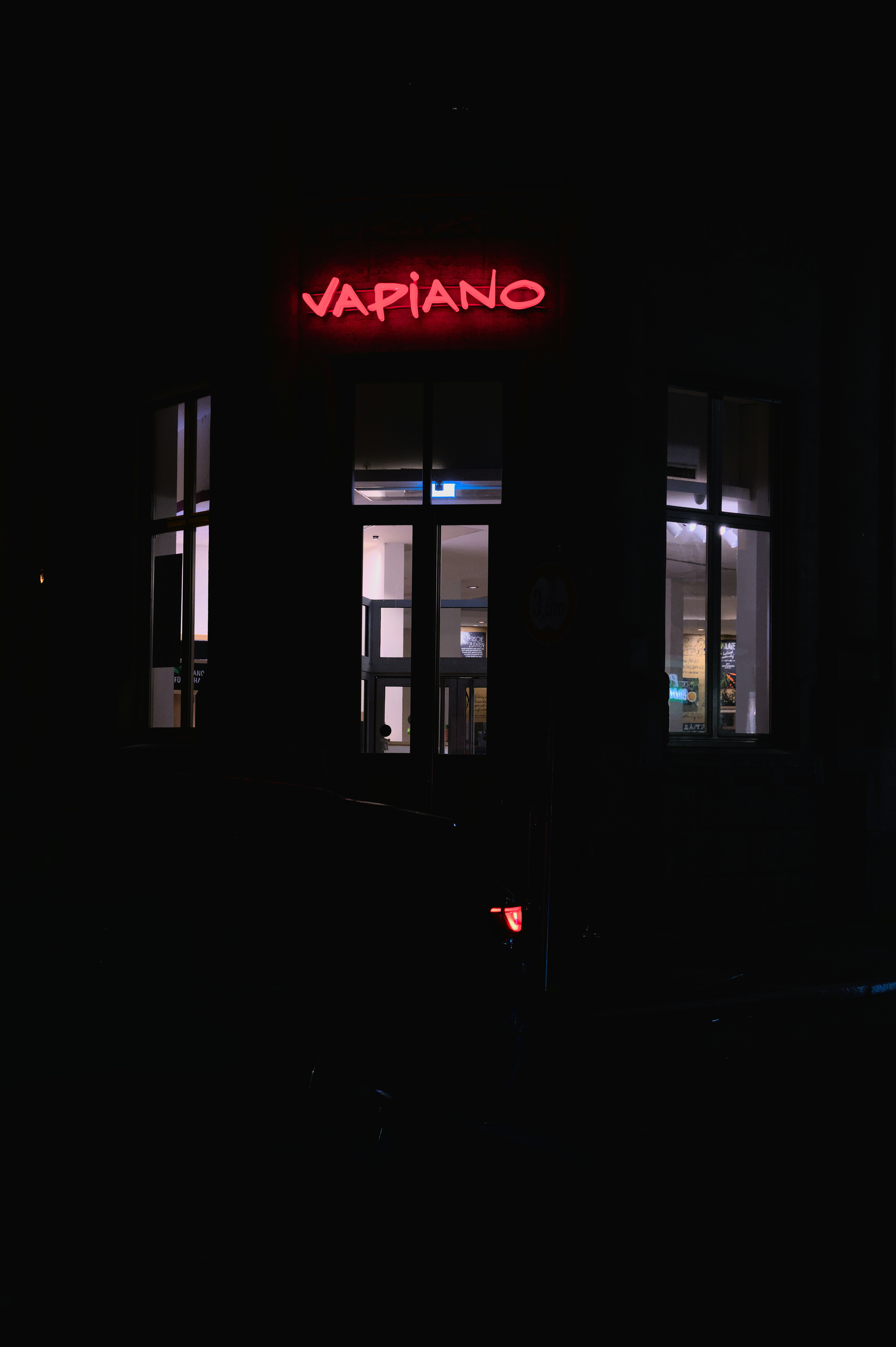 Crimson Neon Above Quiet Windows: Vapiano Nightscape