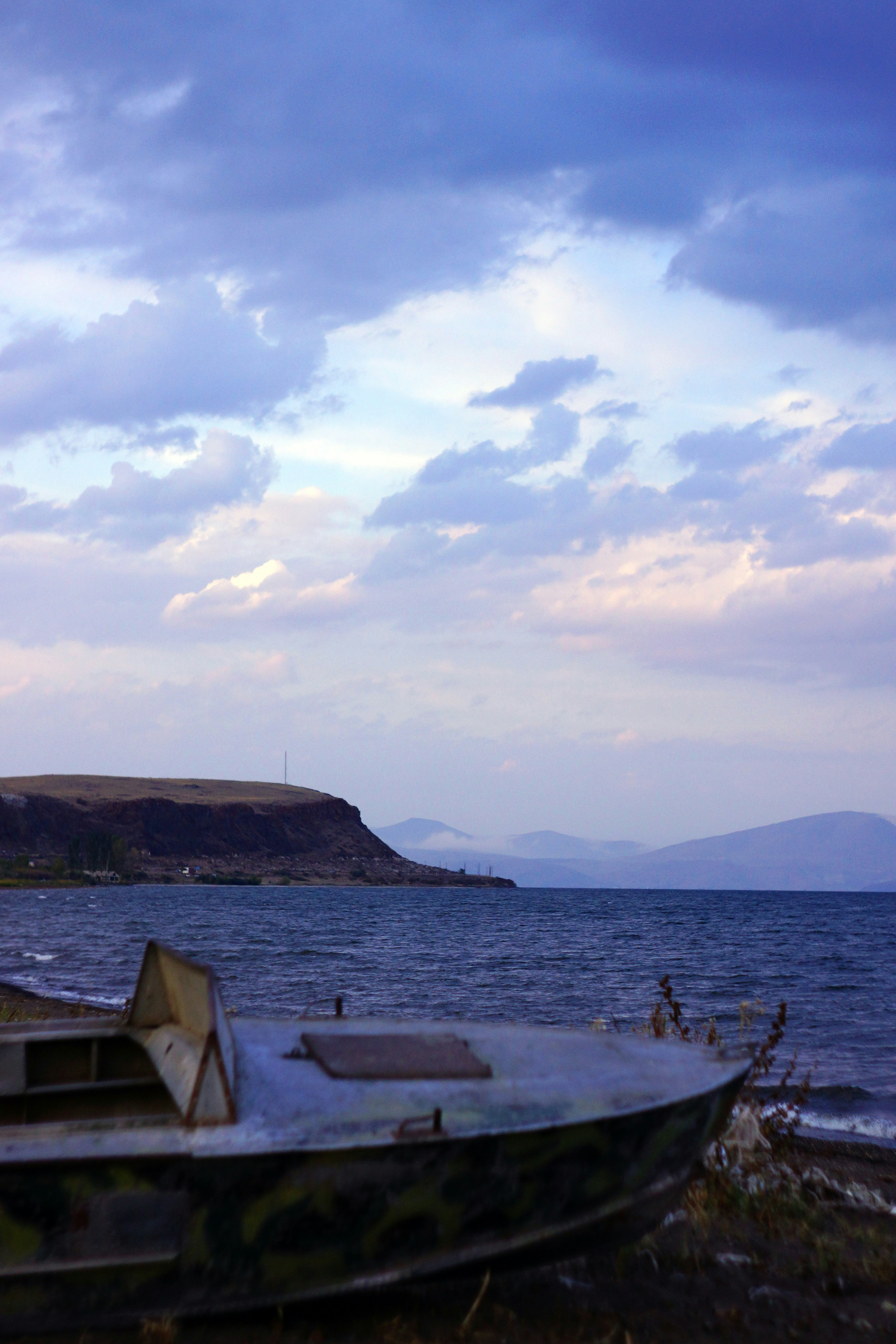a boat sits on the shore of a lake